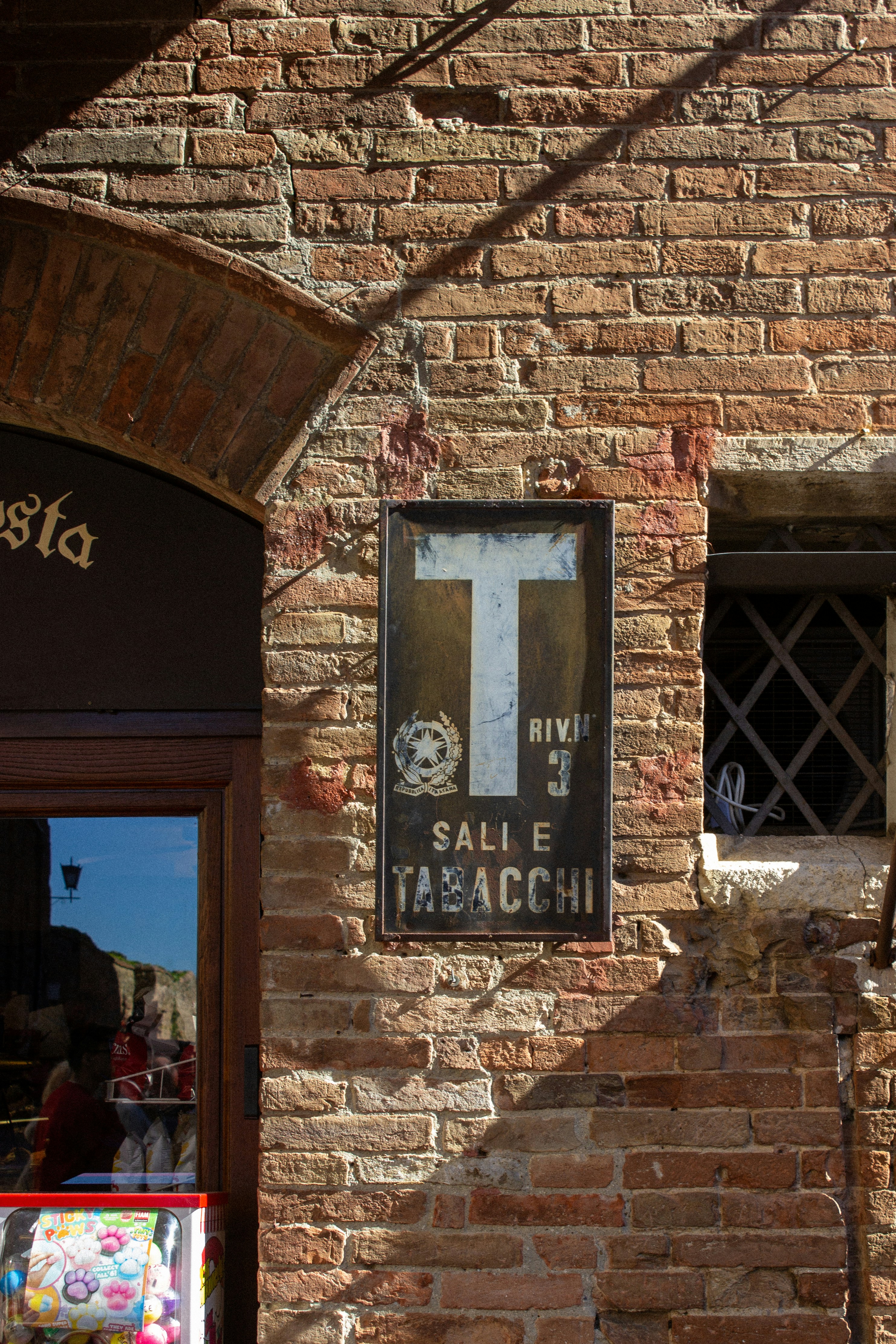 Weathered Sign Adrift on Brick Facade