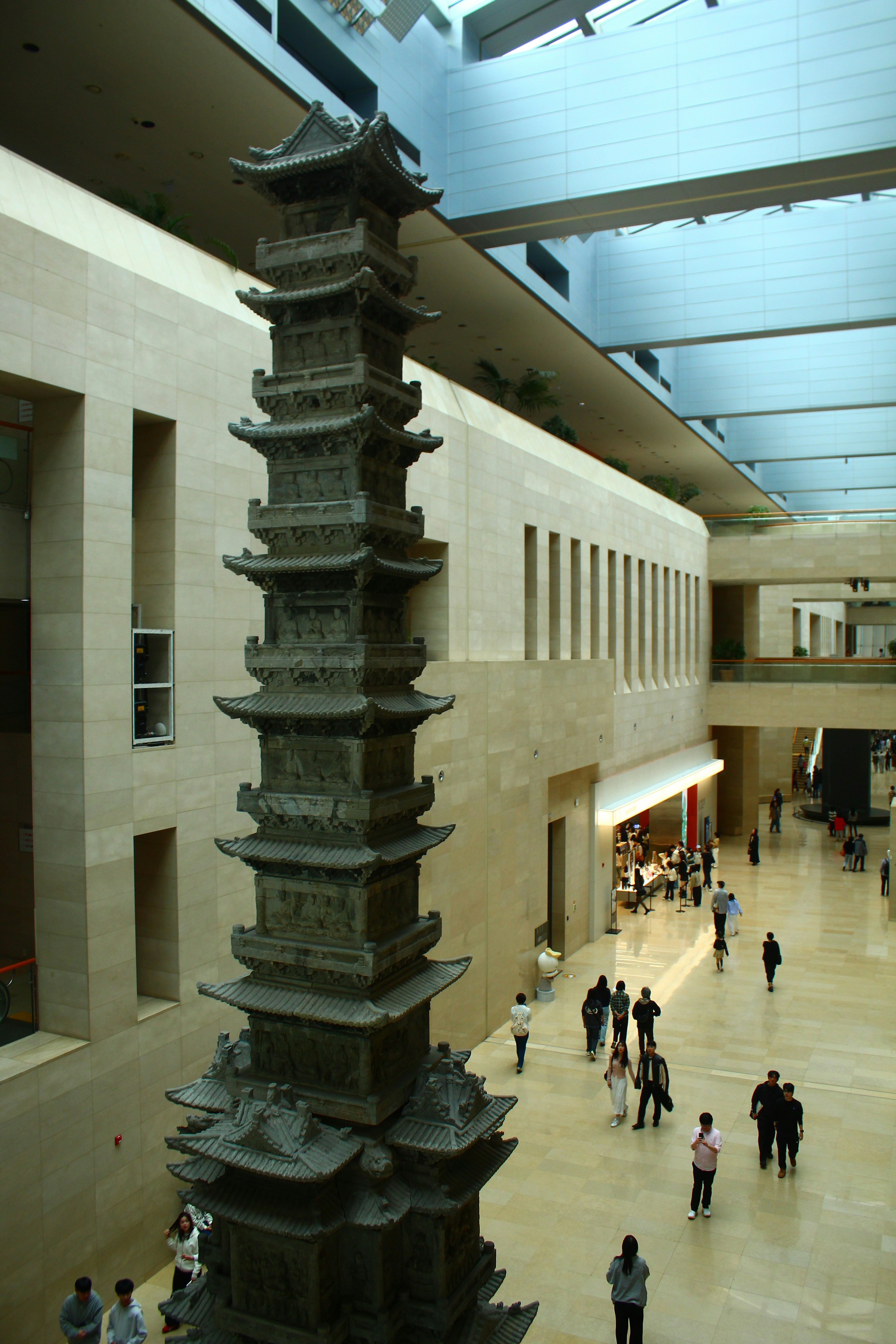 A towering pagoda anchors a sunlit museum atrium