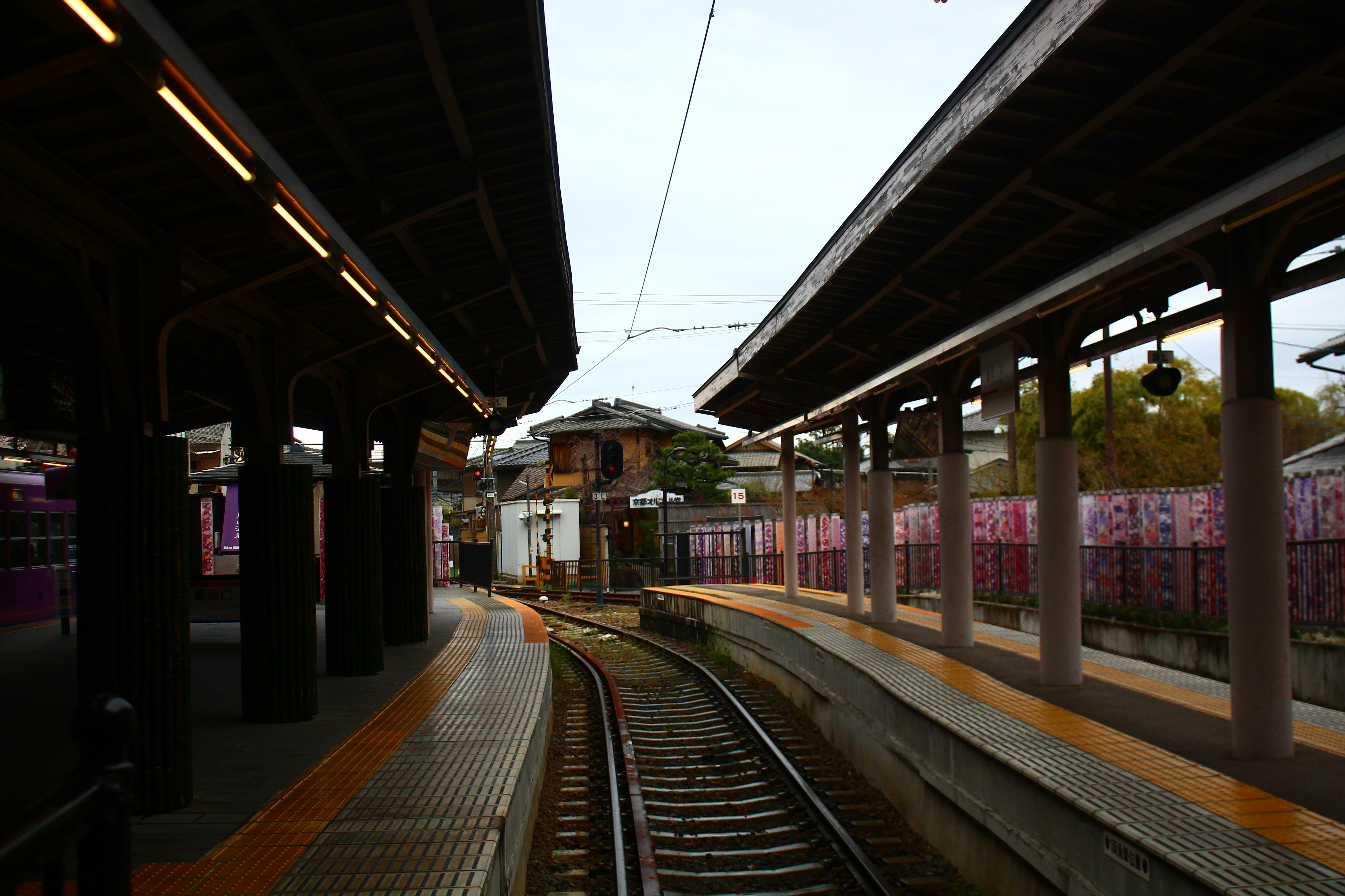 Converging Rails Beneath a Quiet Platform Canopy