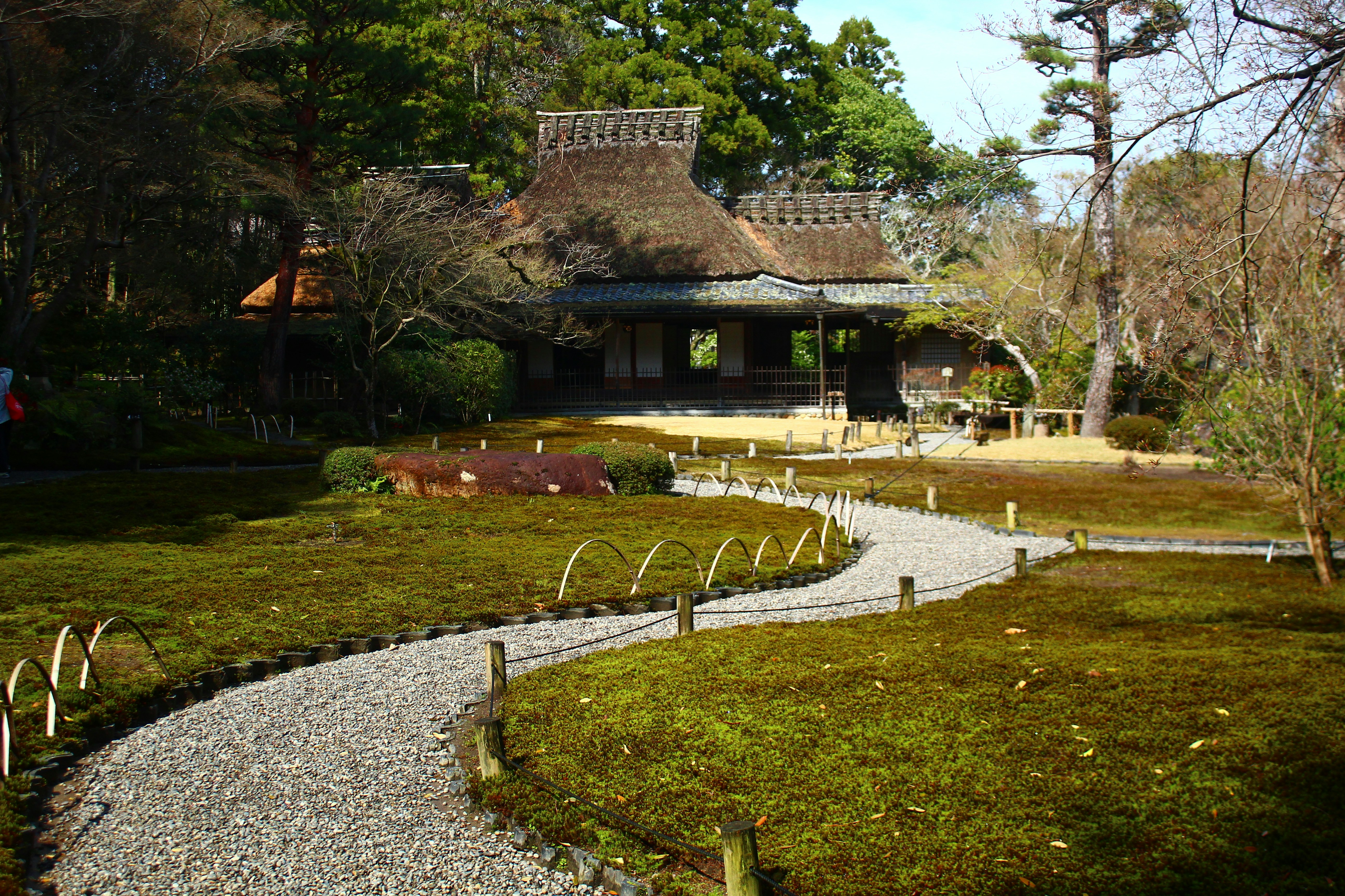 Winding gravel path to a thatched-roof temple