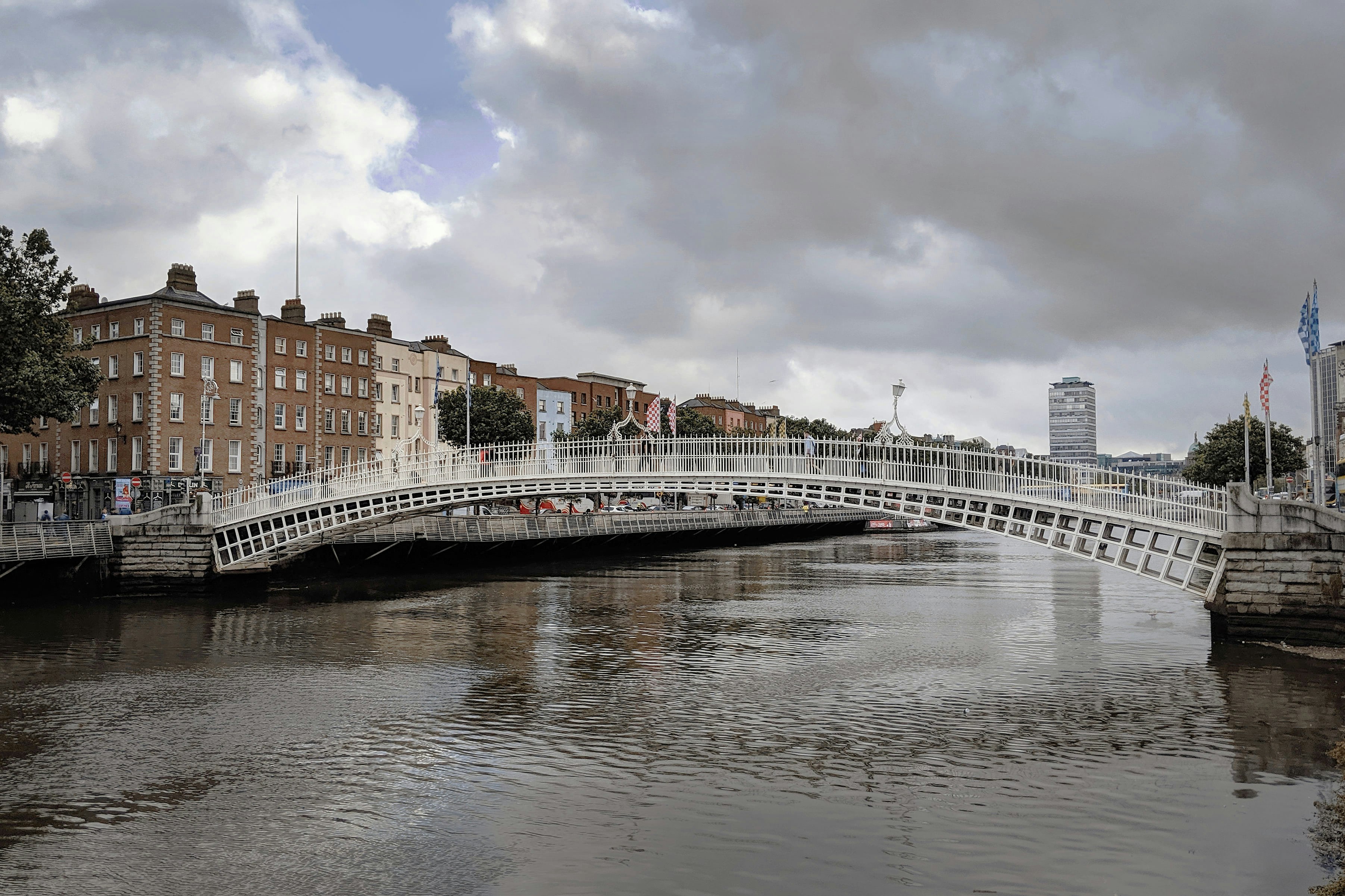 White arched bridge over a calm river in a historic riverside town