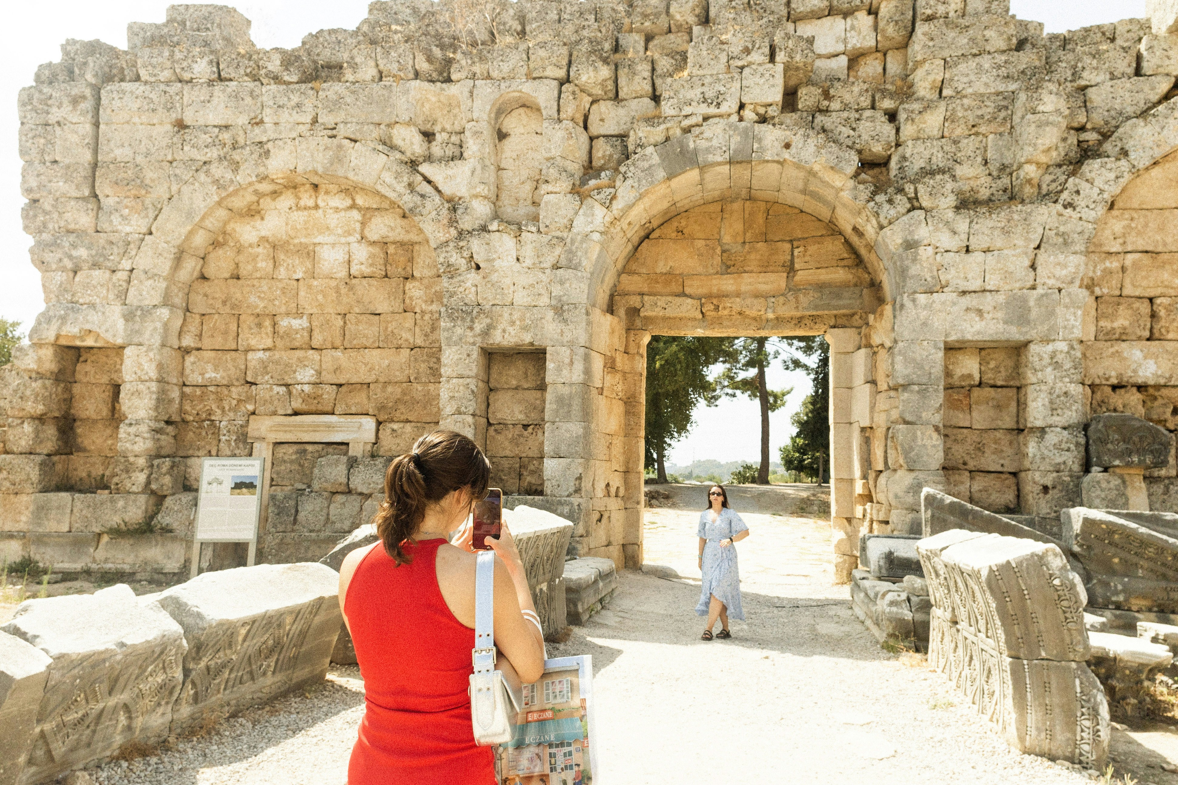 Red-clad visitor at ancient gateframes: a candid encounter at the ruin