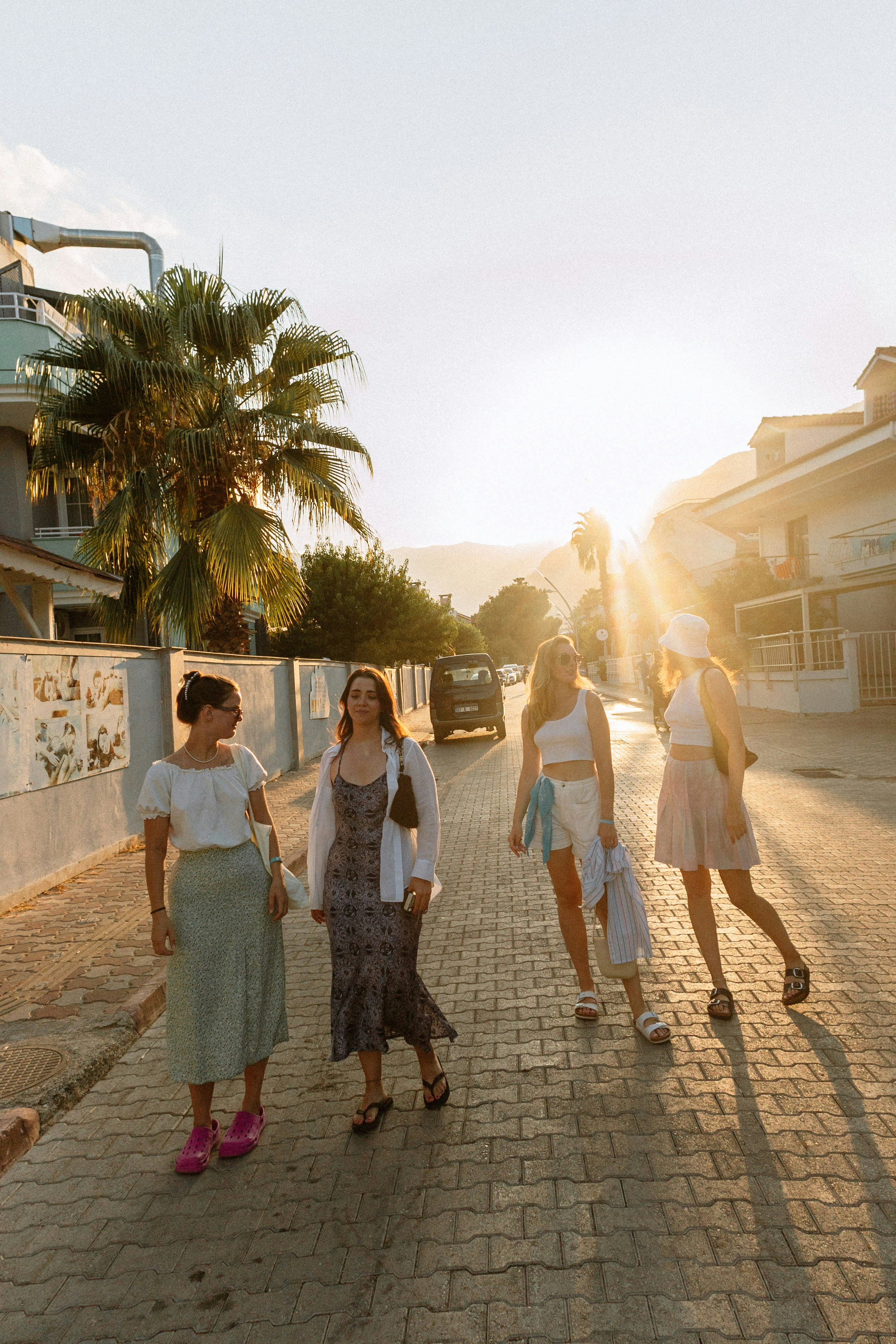 Sunlit Stroll: A Quartet of Friends on a Coastal Street
