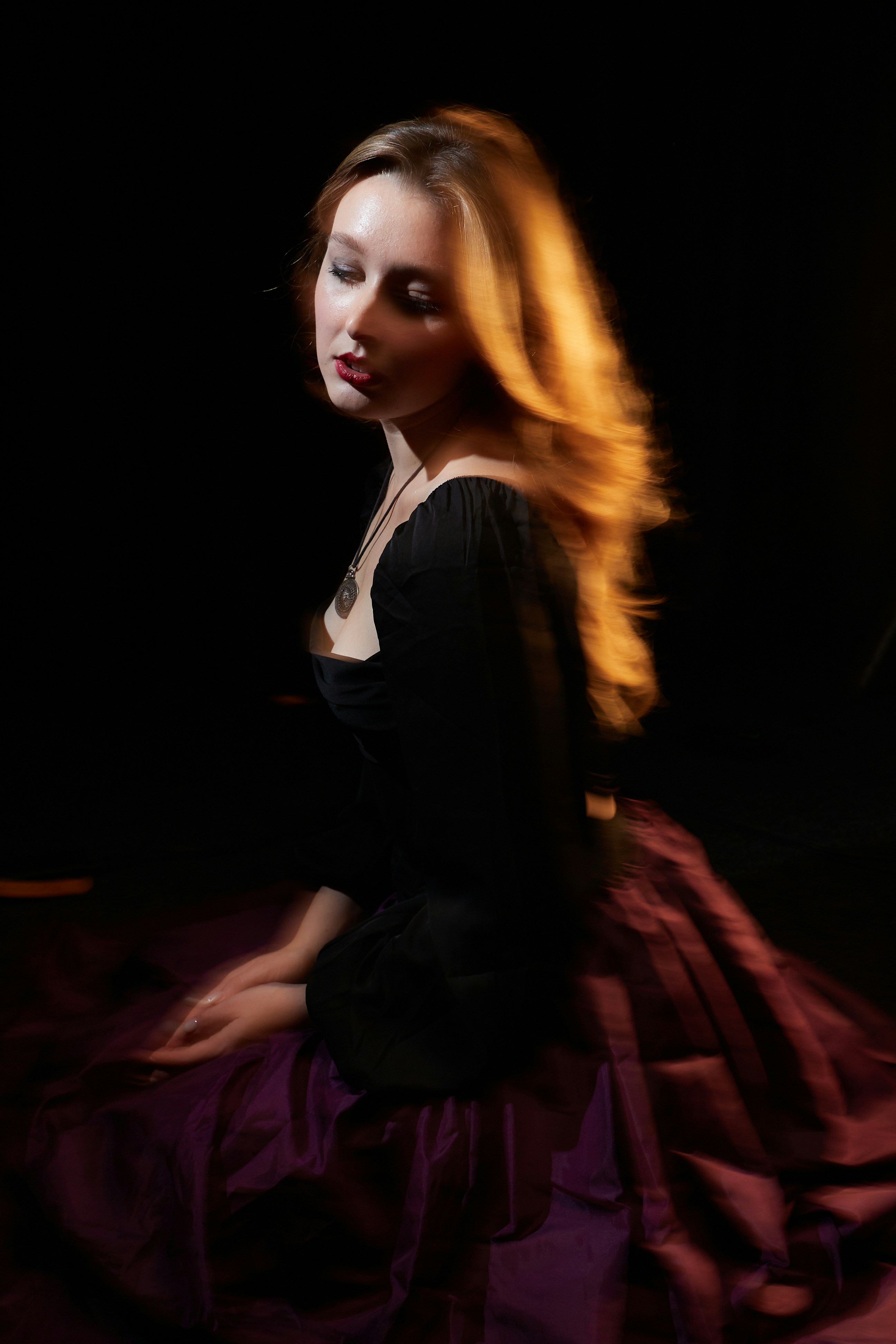 Grace in Motion: A Luminous Portrait of a Dressed Figure in Dim Stage Light