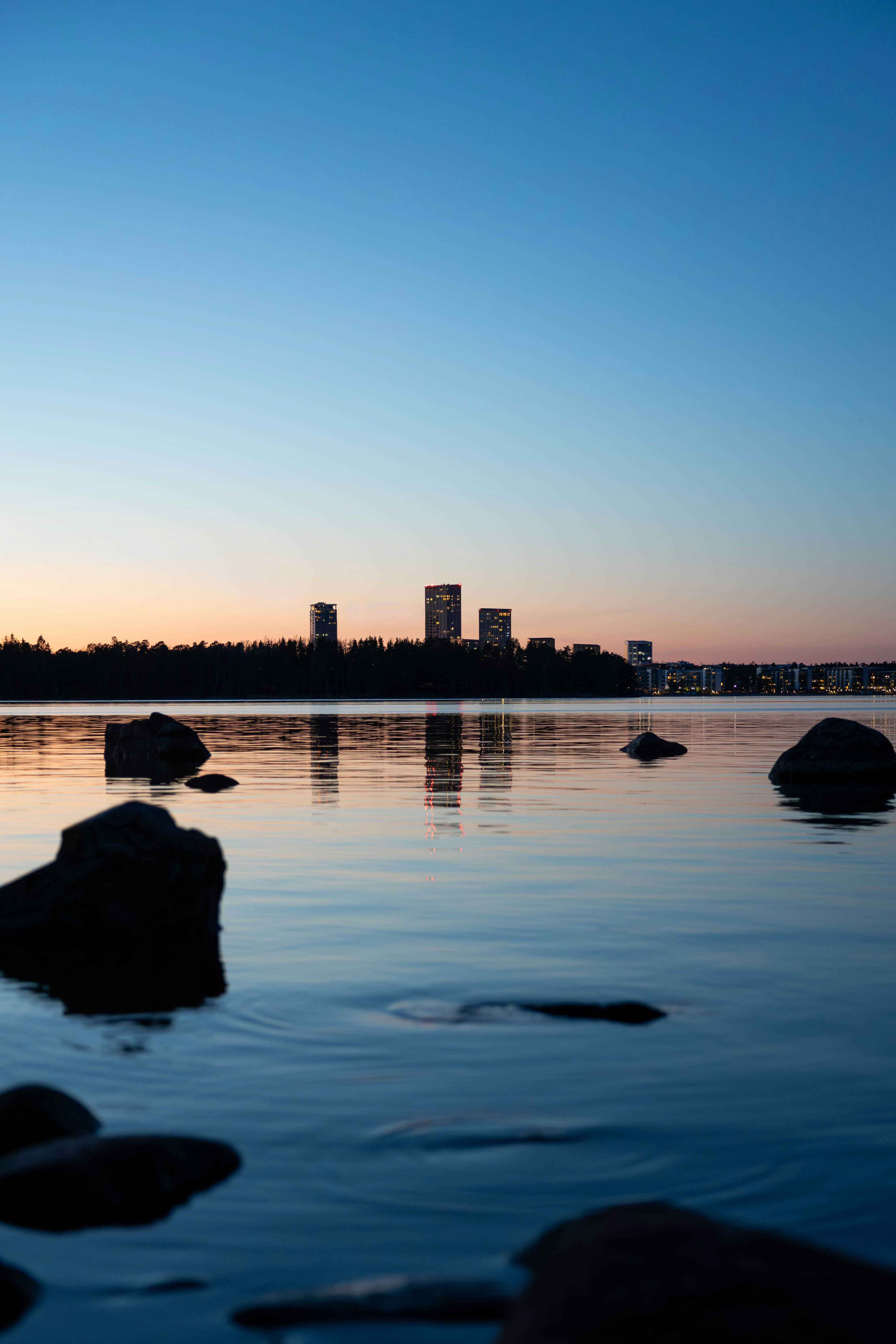 Dusk Over the Quiet Shore: Lights Among the River Silhouette