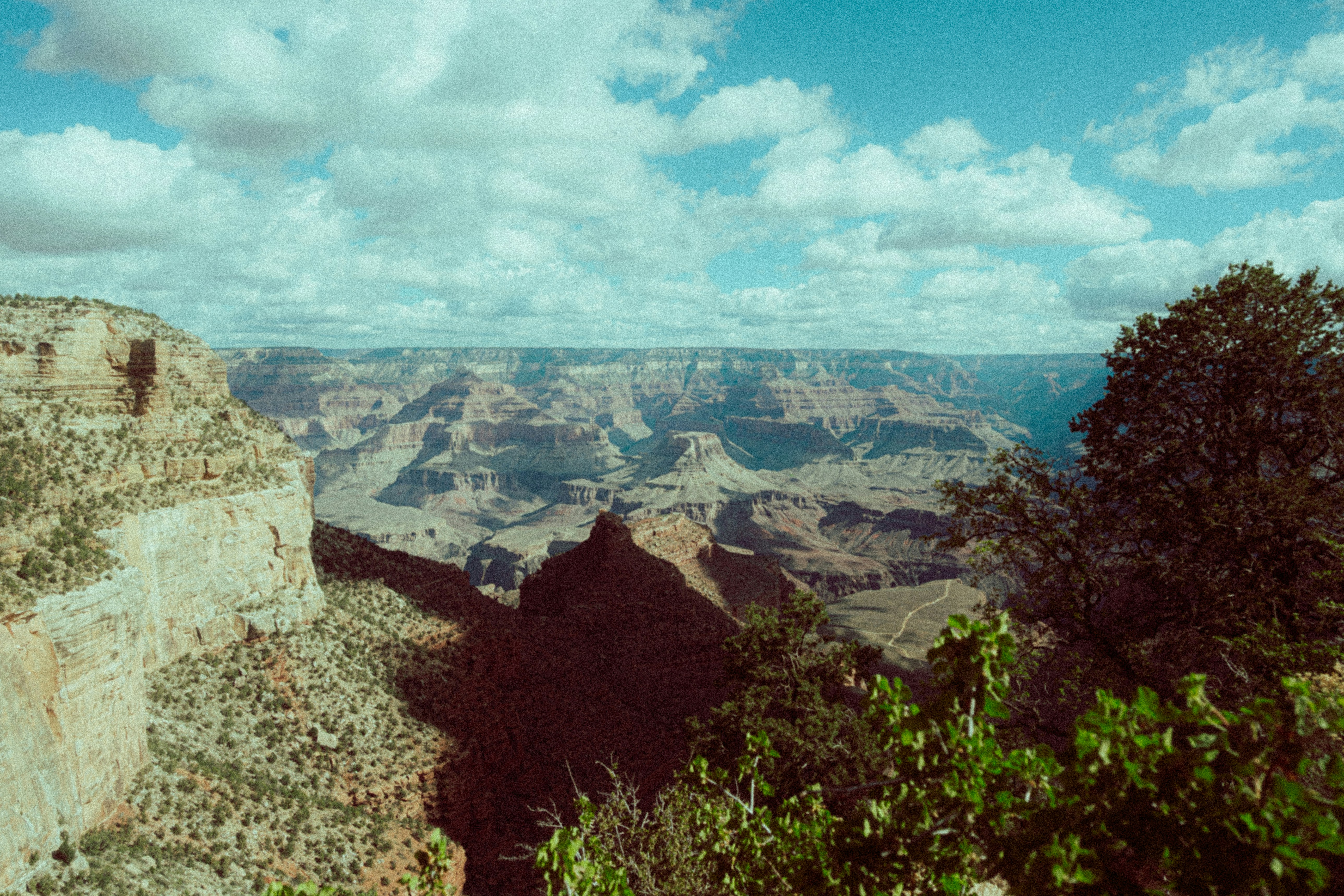 Vast Canyon Rim Under a Cotton-Cloud Sky