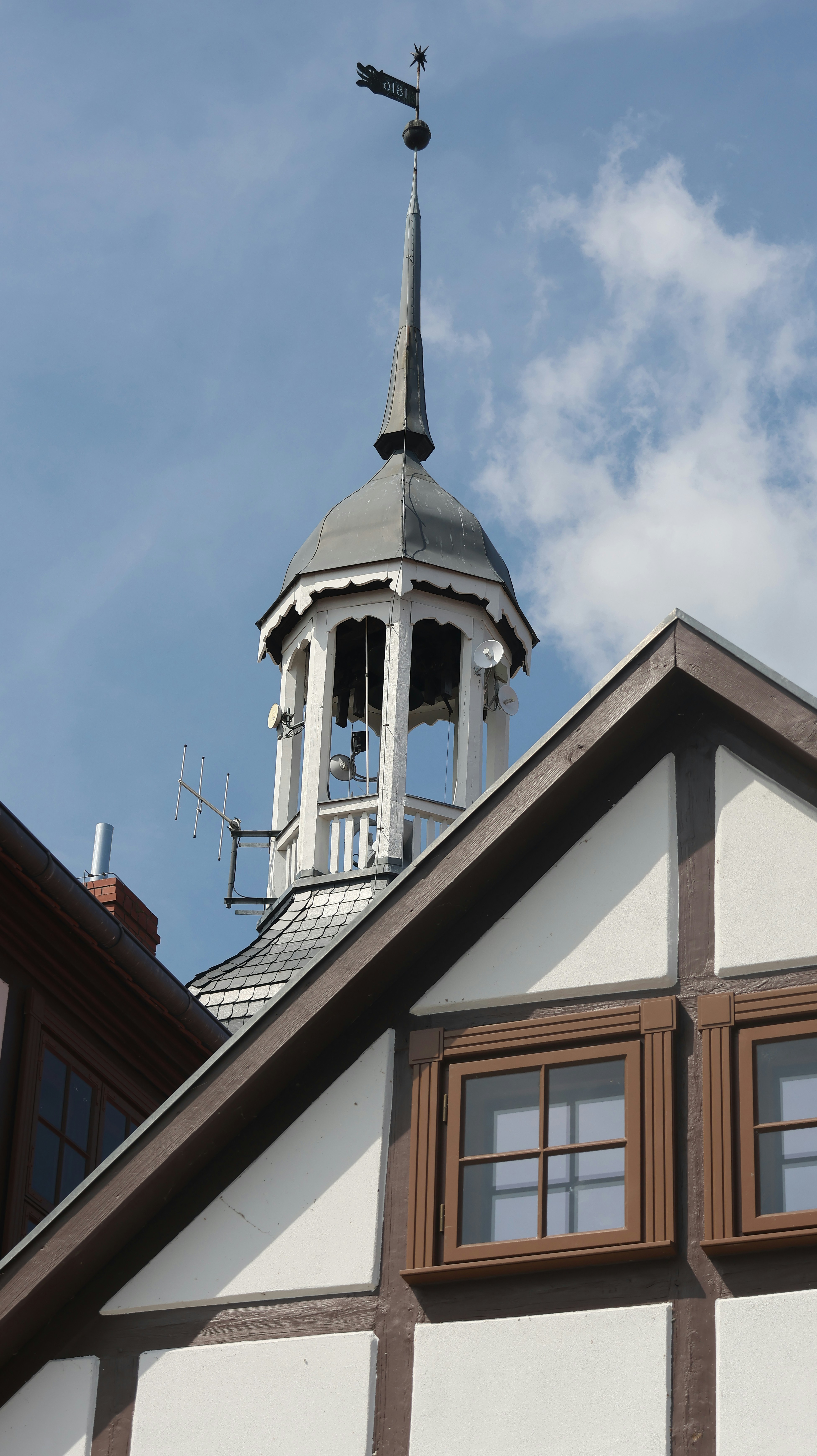 Steeple Crowned with Weather Vane Above Tudor Gable