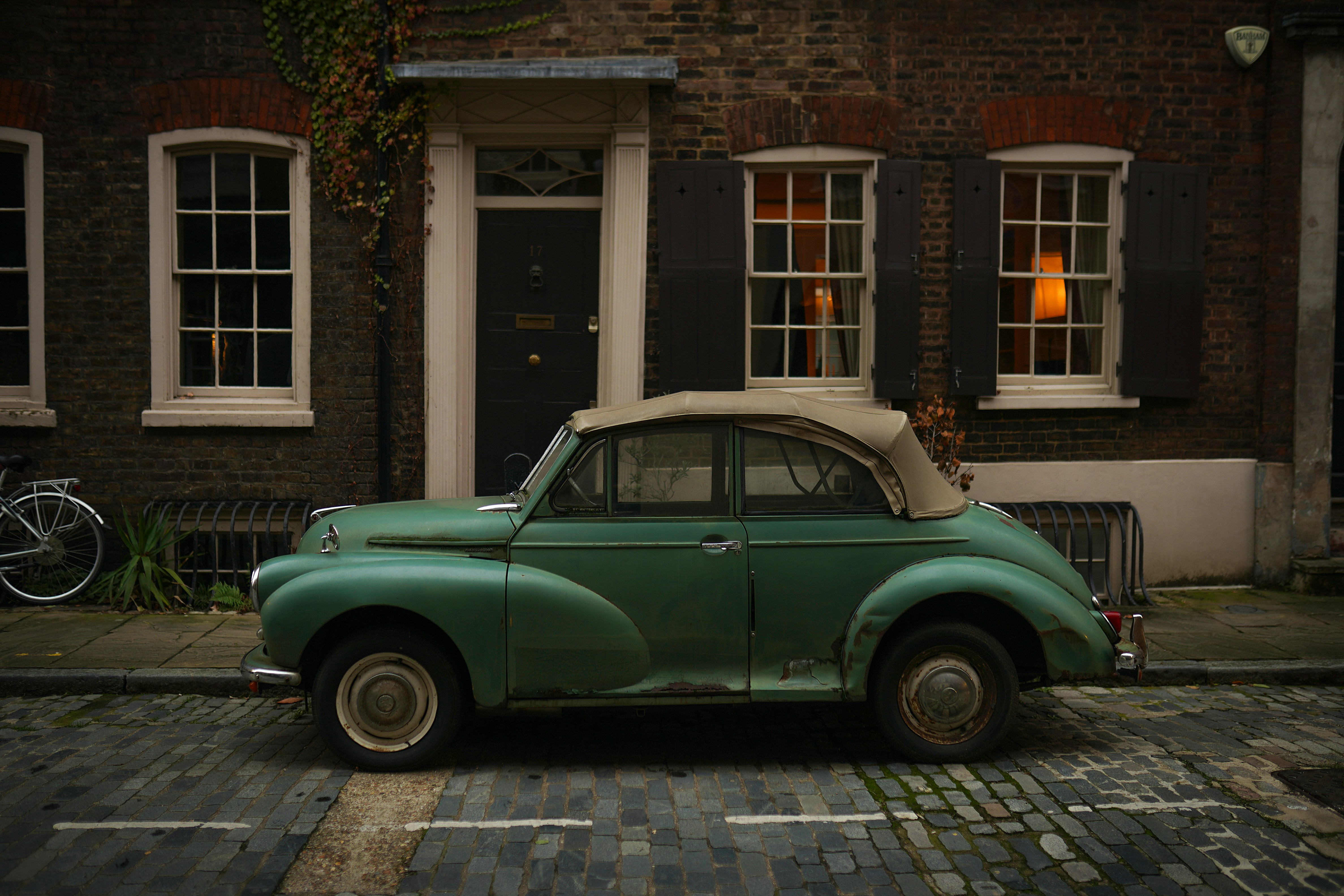 Green Vintage Cruiser Resting Along a Cobblestone Street