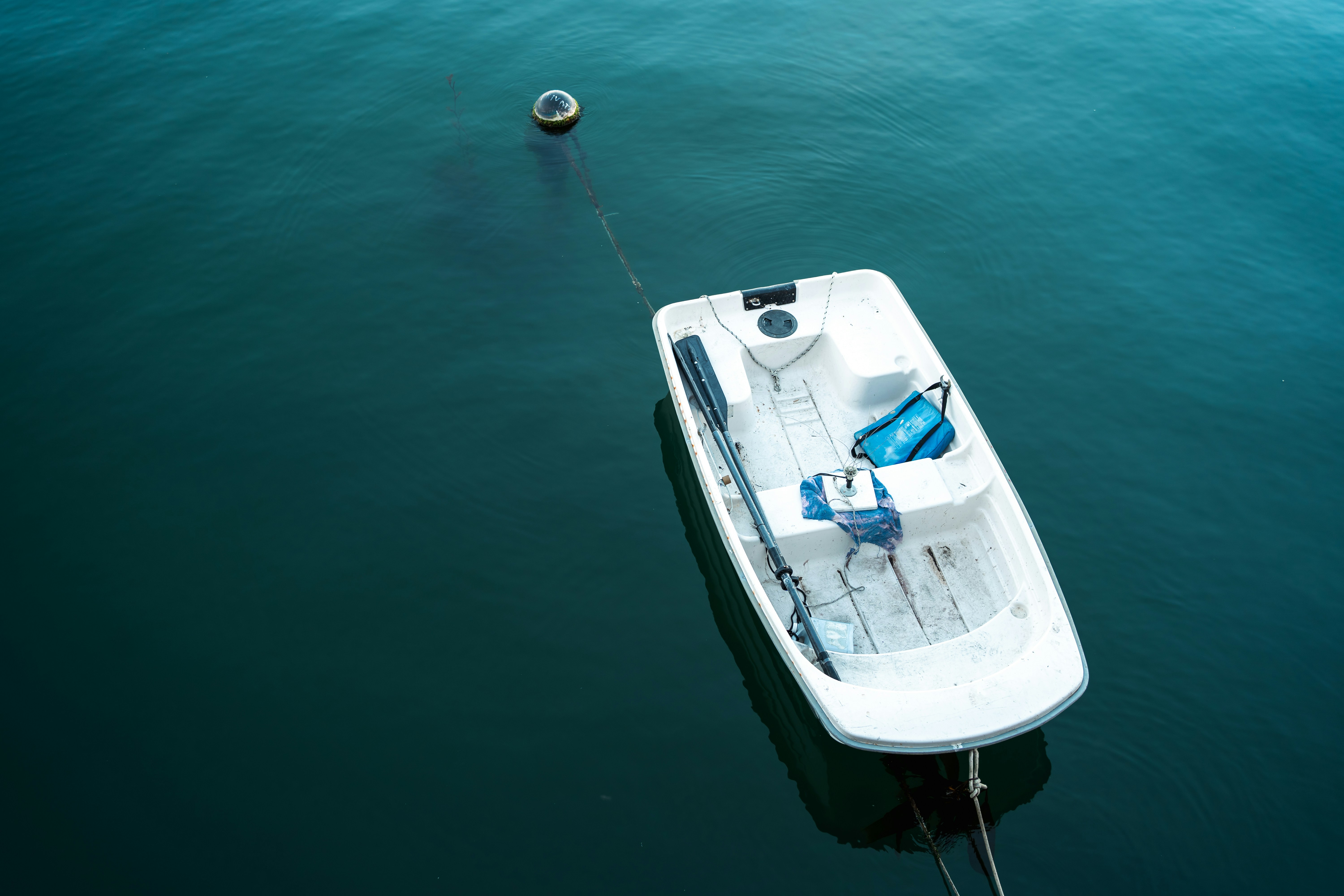 A Solo Boat Drifting in Clear Teal Quiet