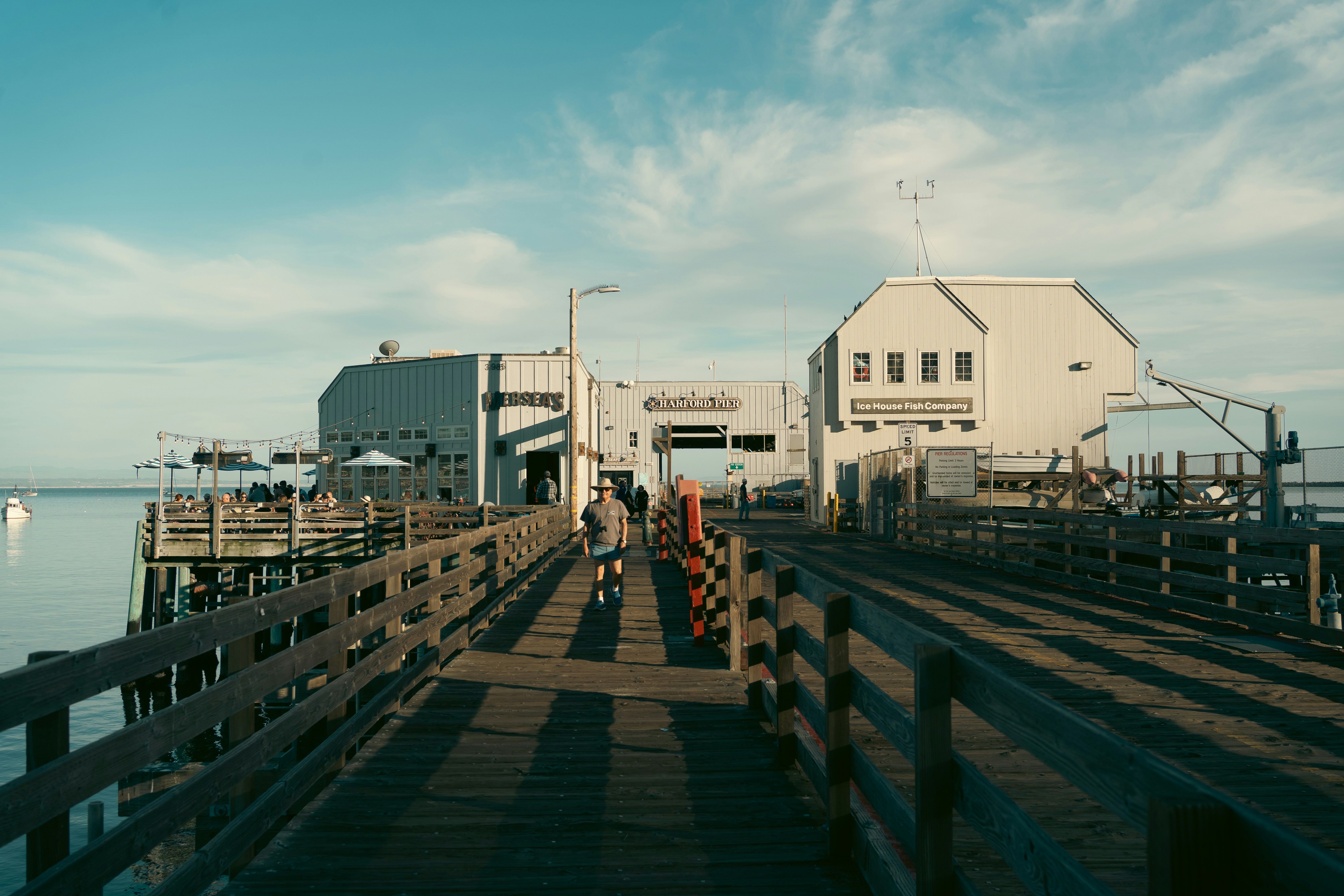 Pierwalk at Golden Hour: Boats, Buildings, and Weathered Rails