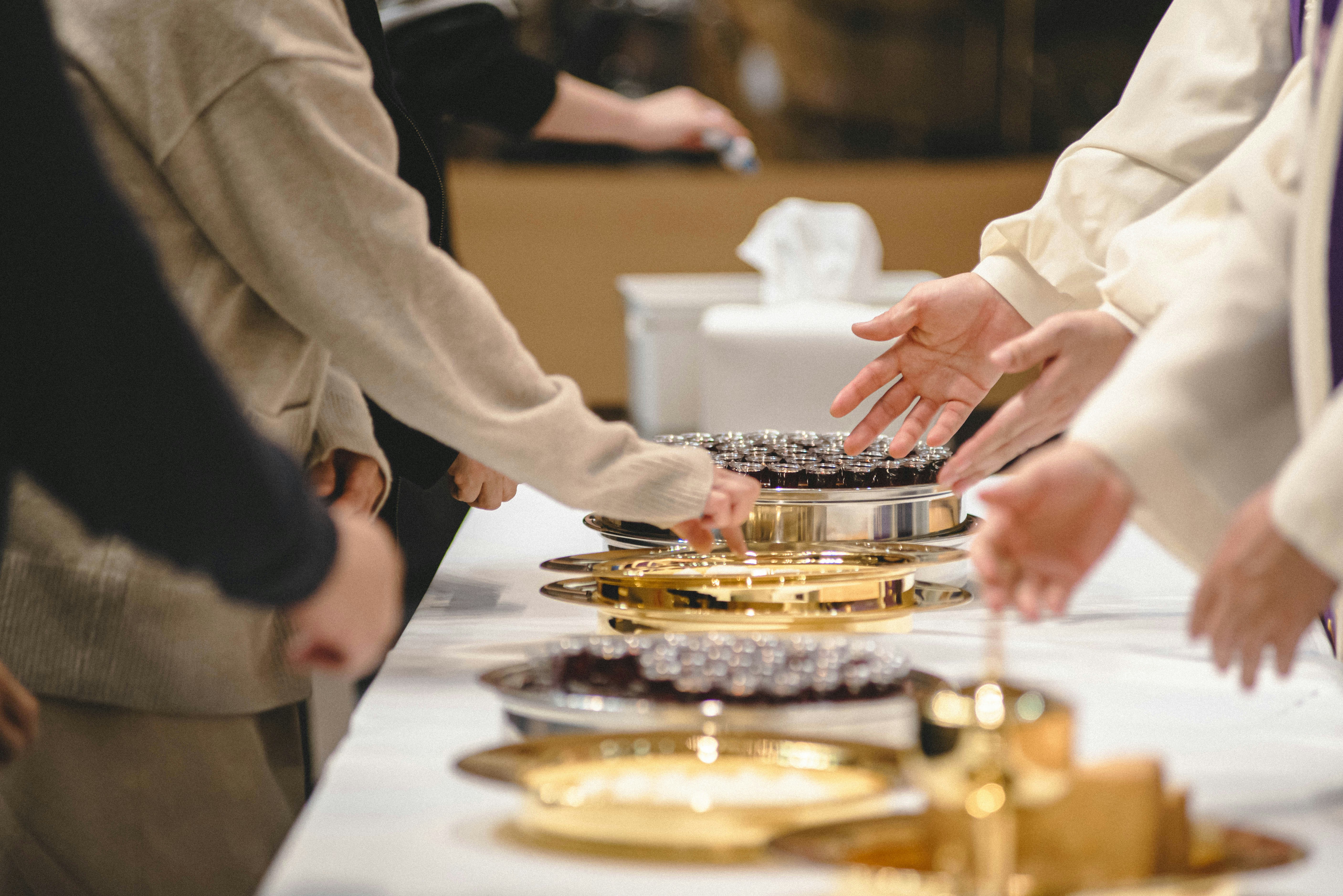 Hands in Line: A Gentle Exchange Over a Row of Servant Trays