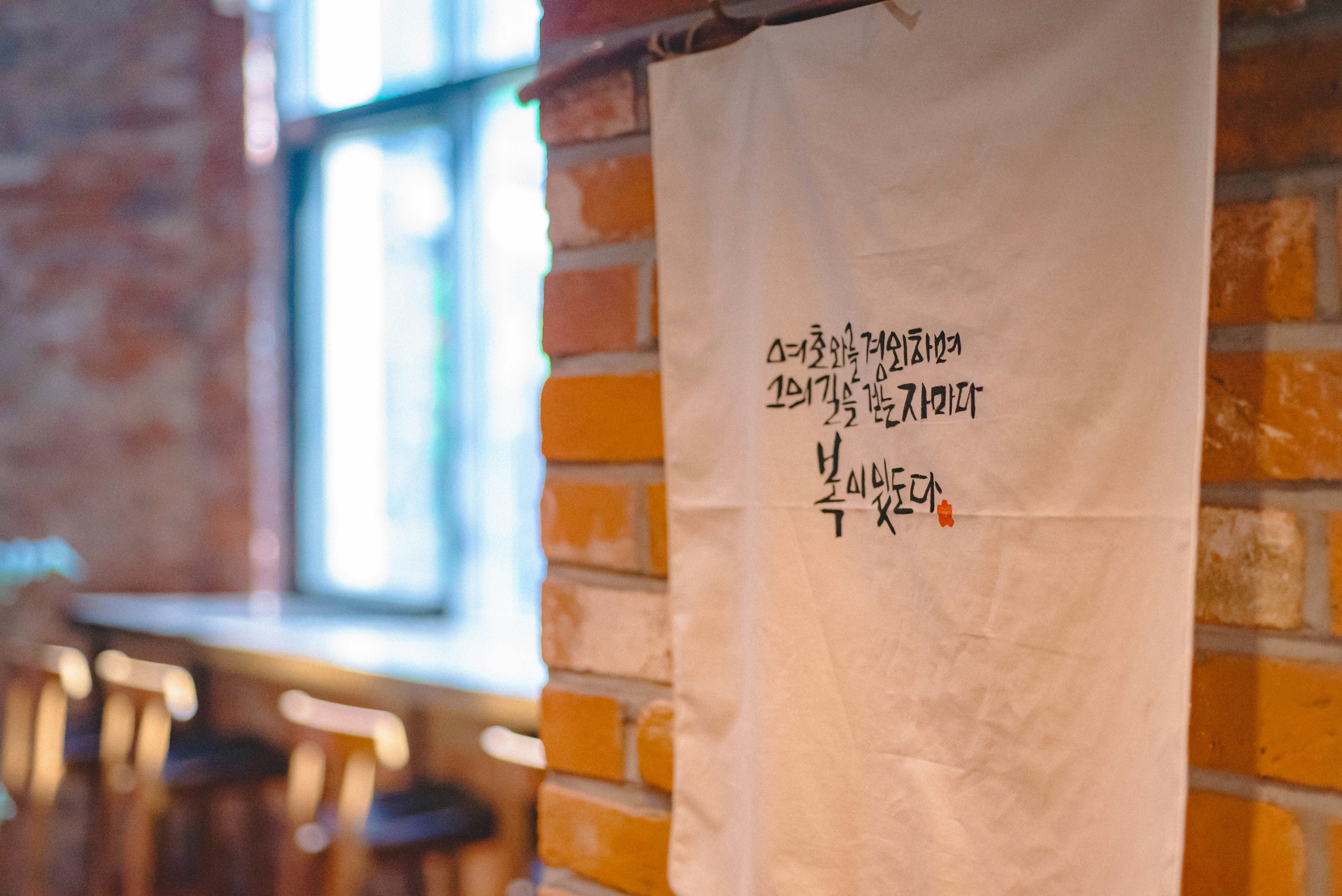 Korean Script Banner Against Brick Wall in Quiet Café