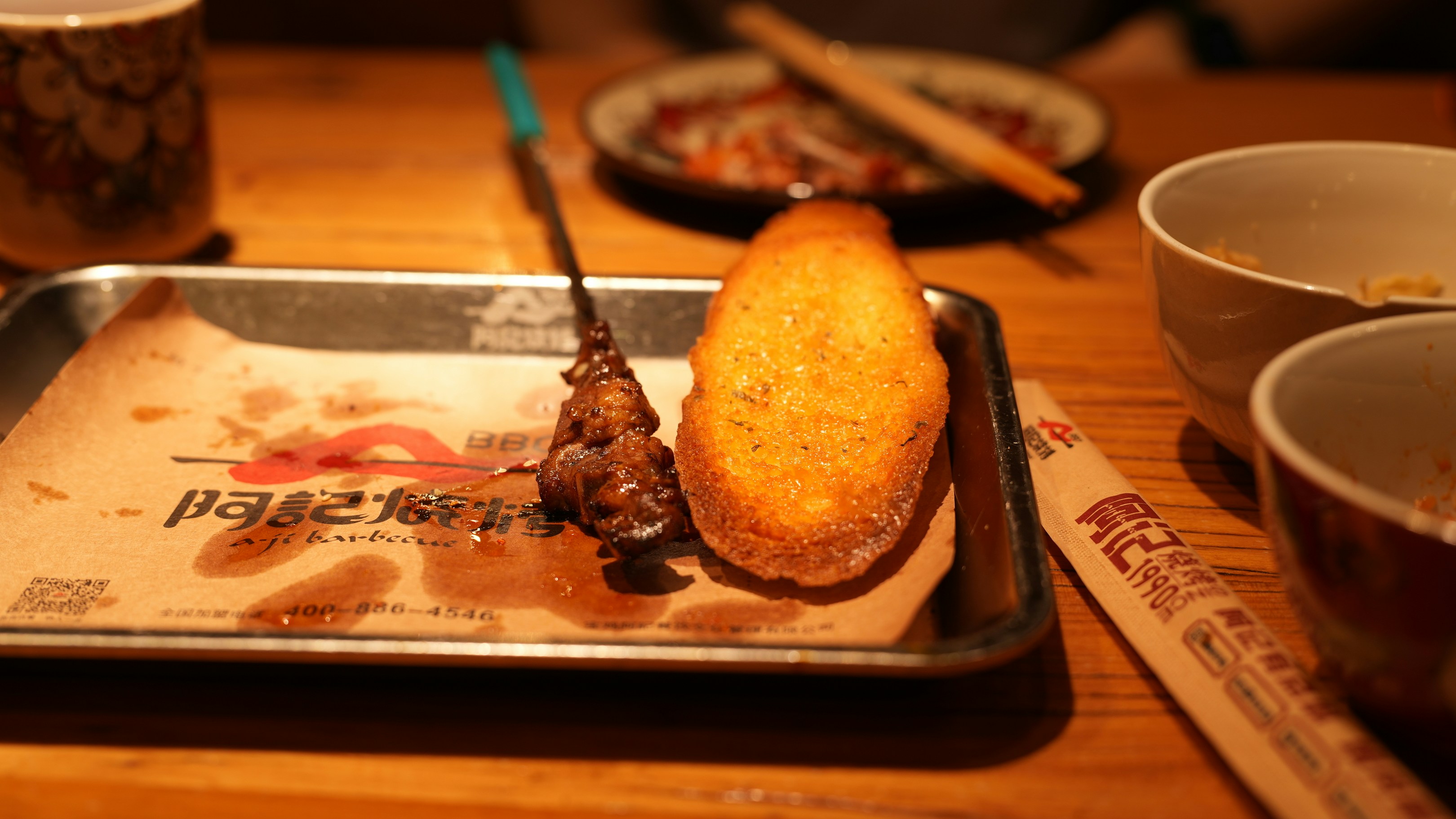 Charred Skewer and Crispy Crostini on a Wooden Tray