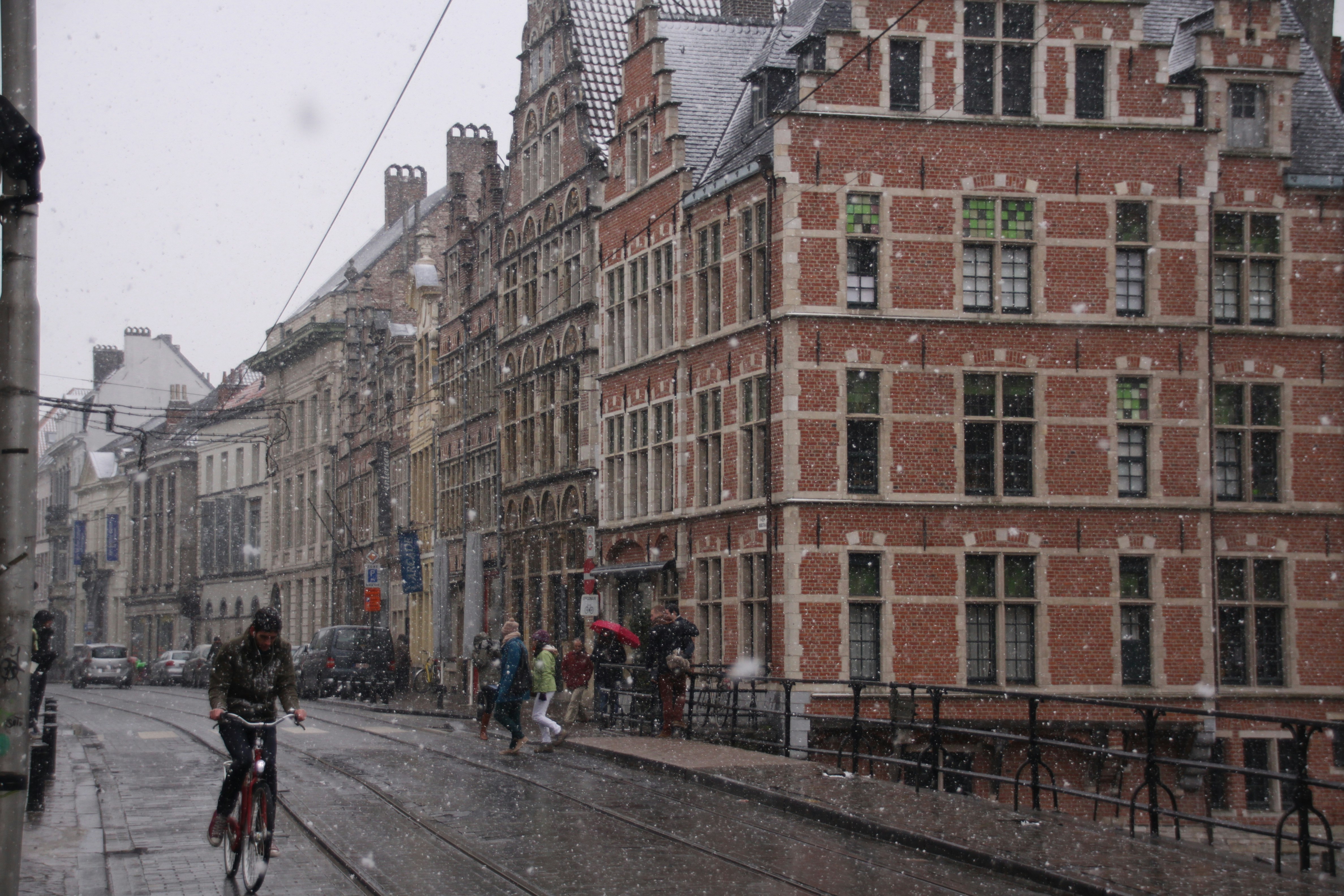 Snow-dusted Canal Street: Riders, Pedestrians, and Brick Facades