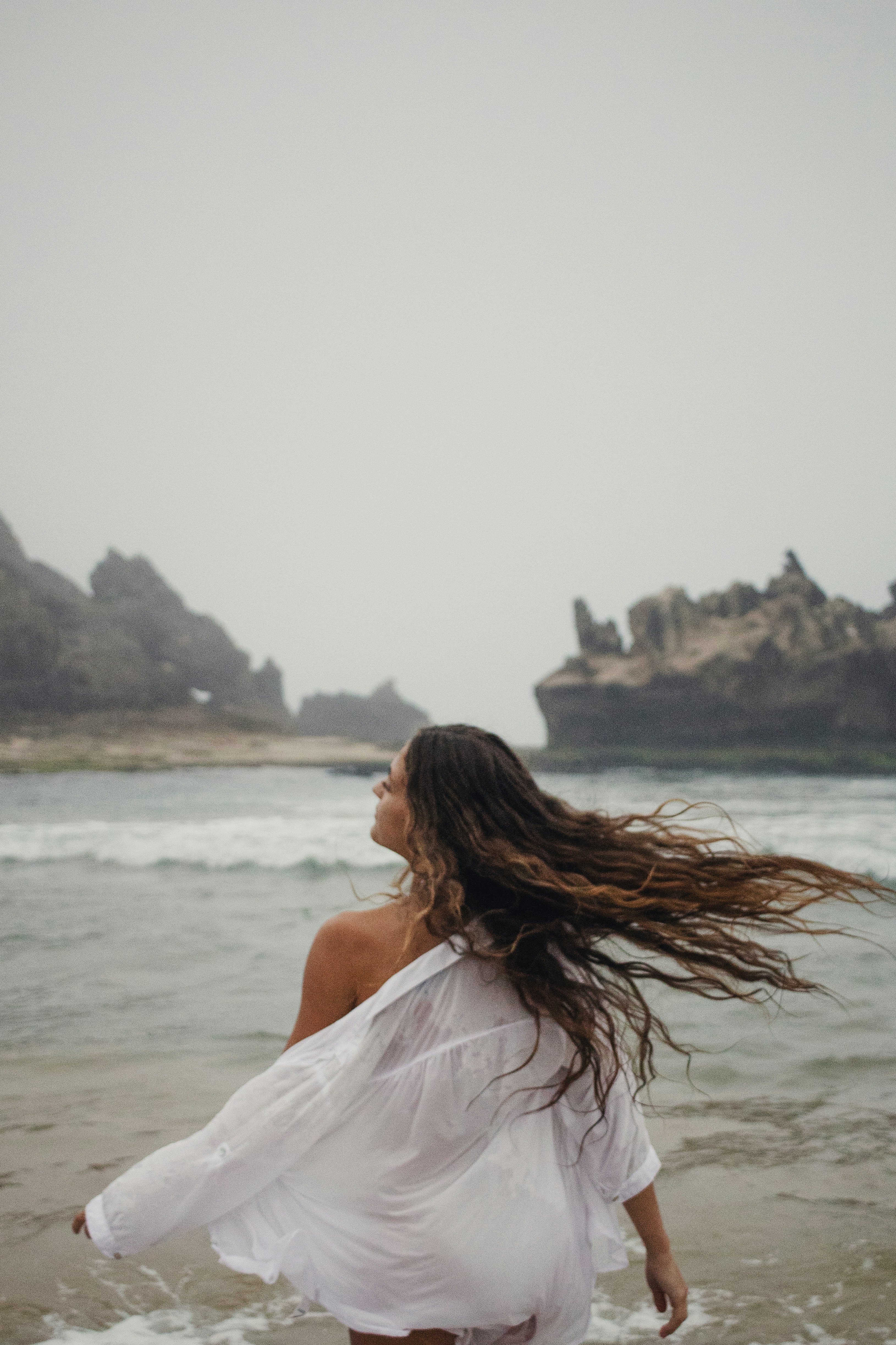 Graceful Turn: Woman in White Against a Seascape