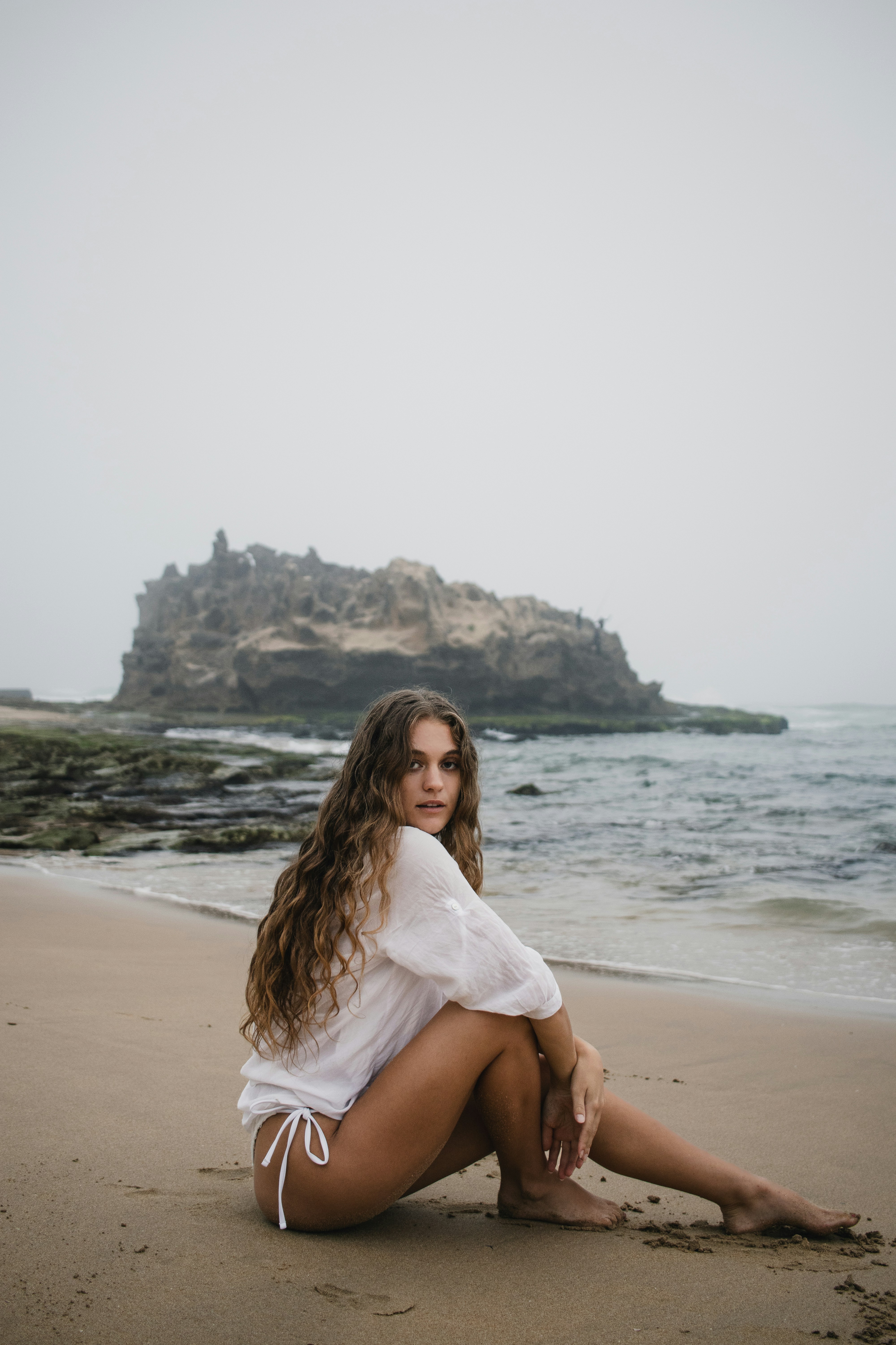 Sea-Breeze Quiet: Woman by the Rock at Dusk