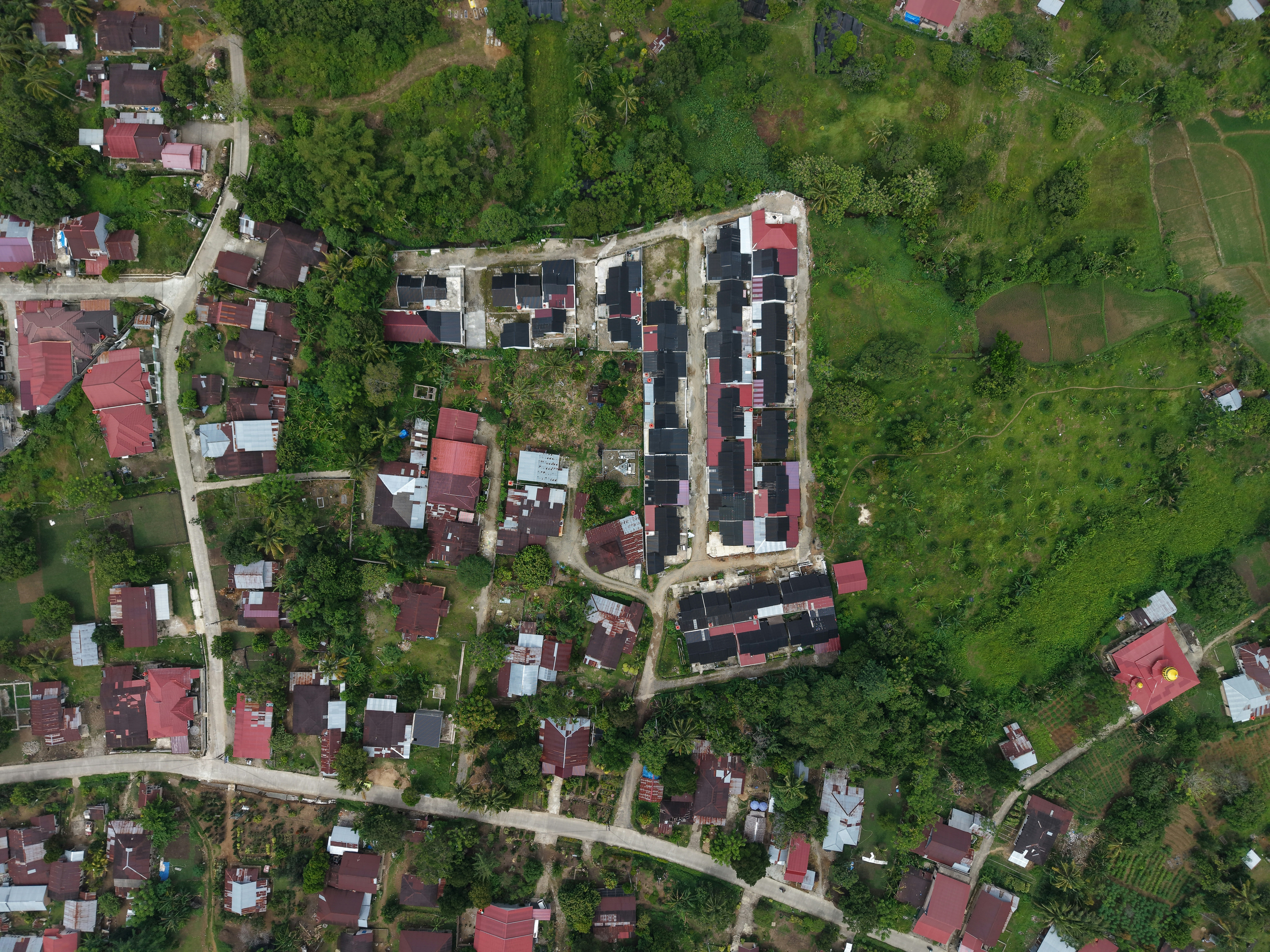 Aerial Patchwork: Village Streets Converge in a Green Patch