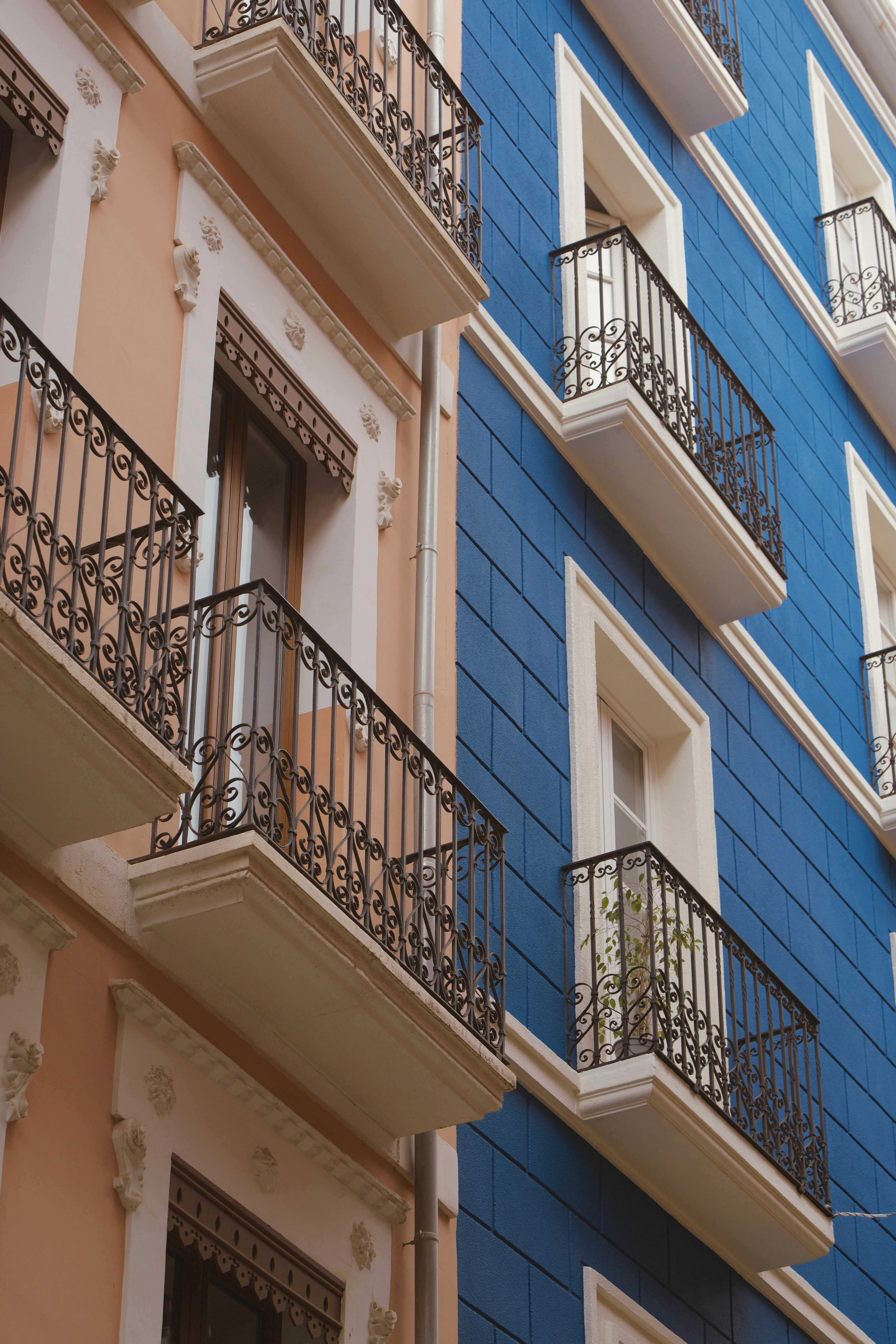 Contrasting façades: peach and cobalt with ornate balconies