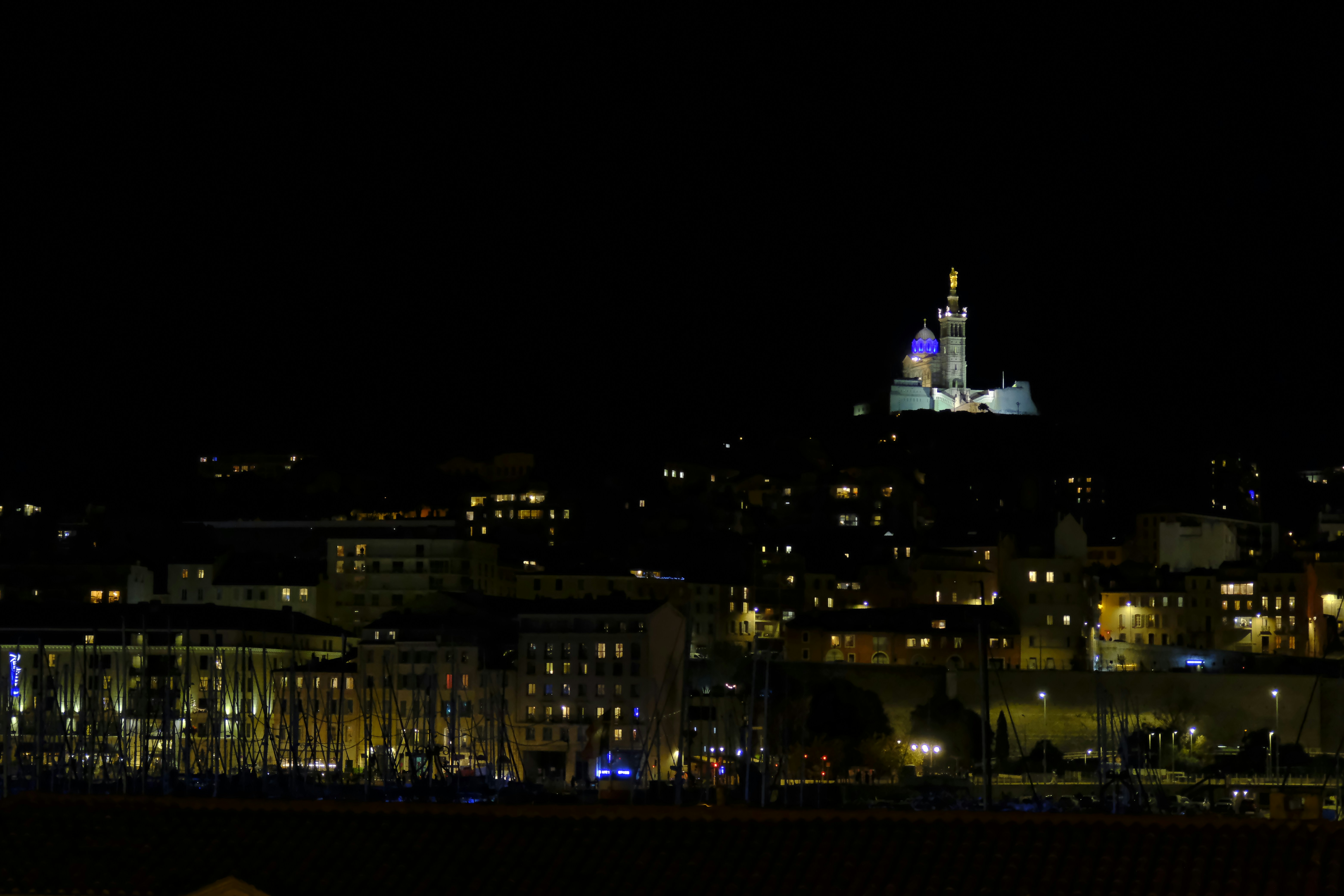 Lighthouse Glow above a quiet harbor at night