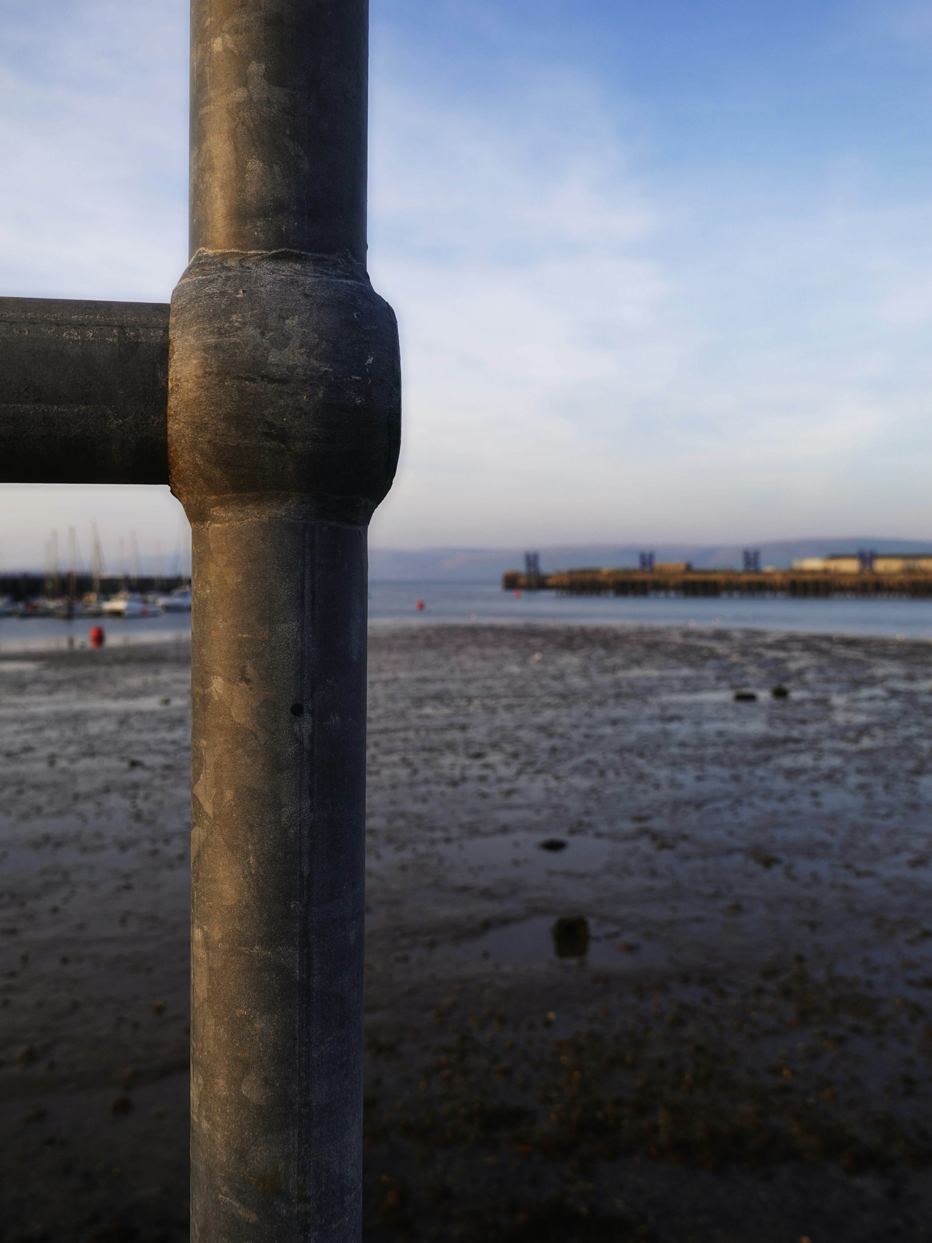 Anchor of the Pier: Weathered Steel Framing against a Quiet Shore