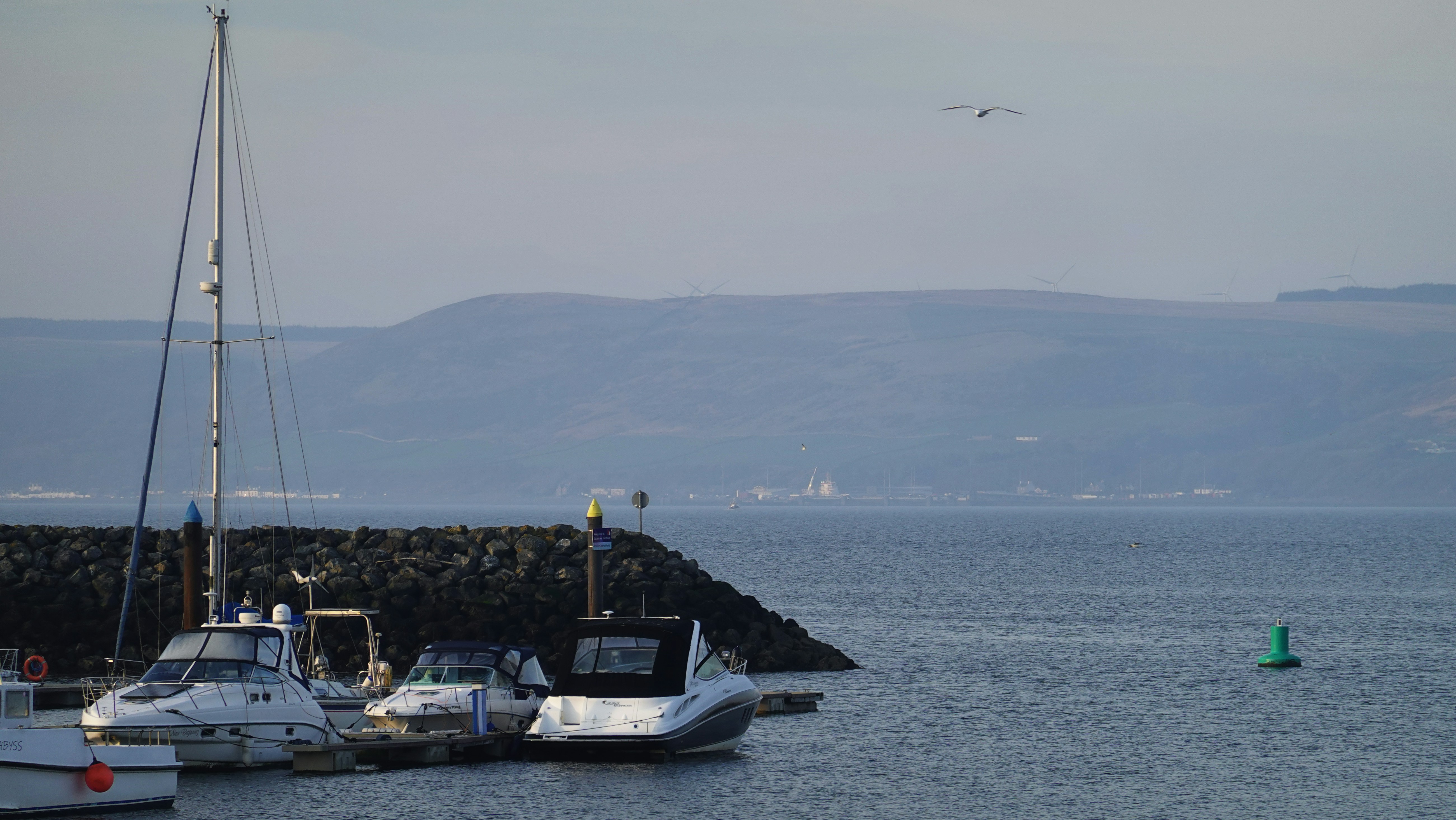 Harbor Calm: Boats at Rest along a Sea-Wacing Breakwater