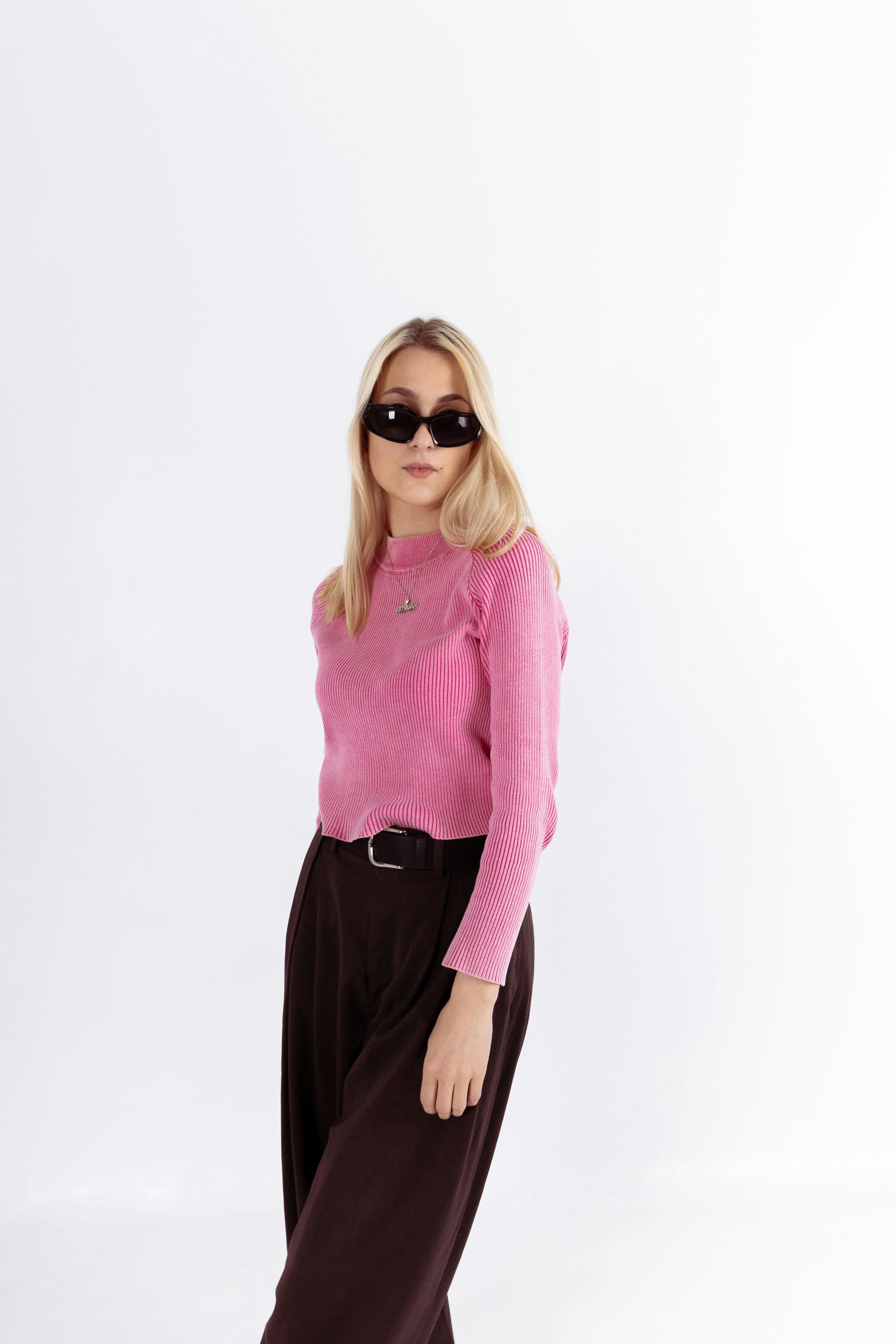 Pink knit silhouette: a stylish portrait in a sparse studio