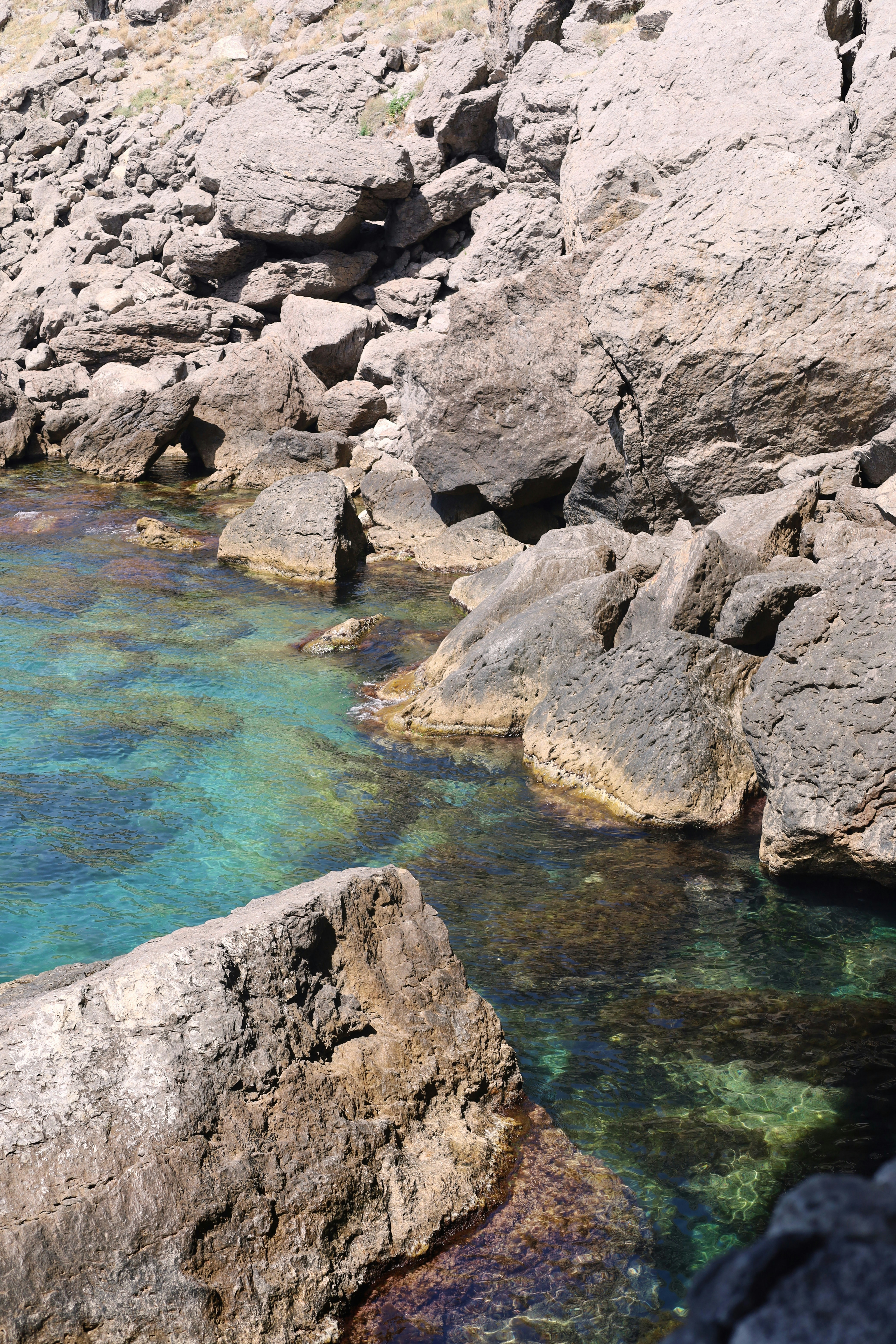 Hidden Tides: Crystalline Blue Waters Among rugged Grey Rocks