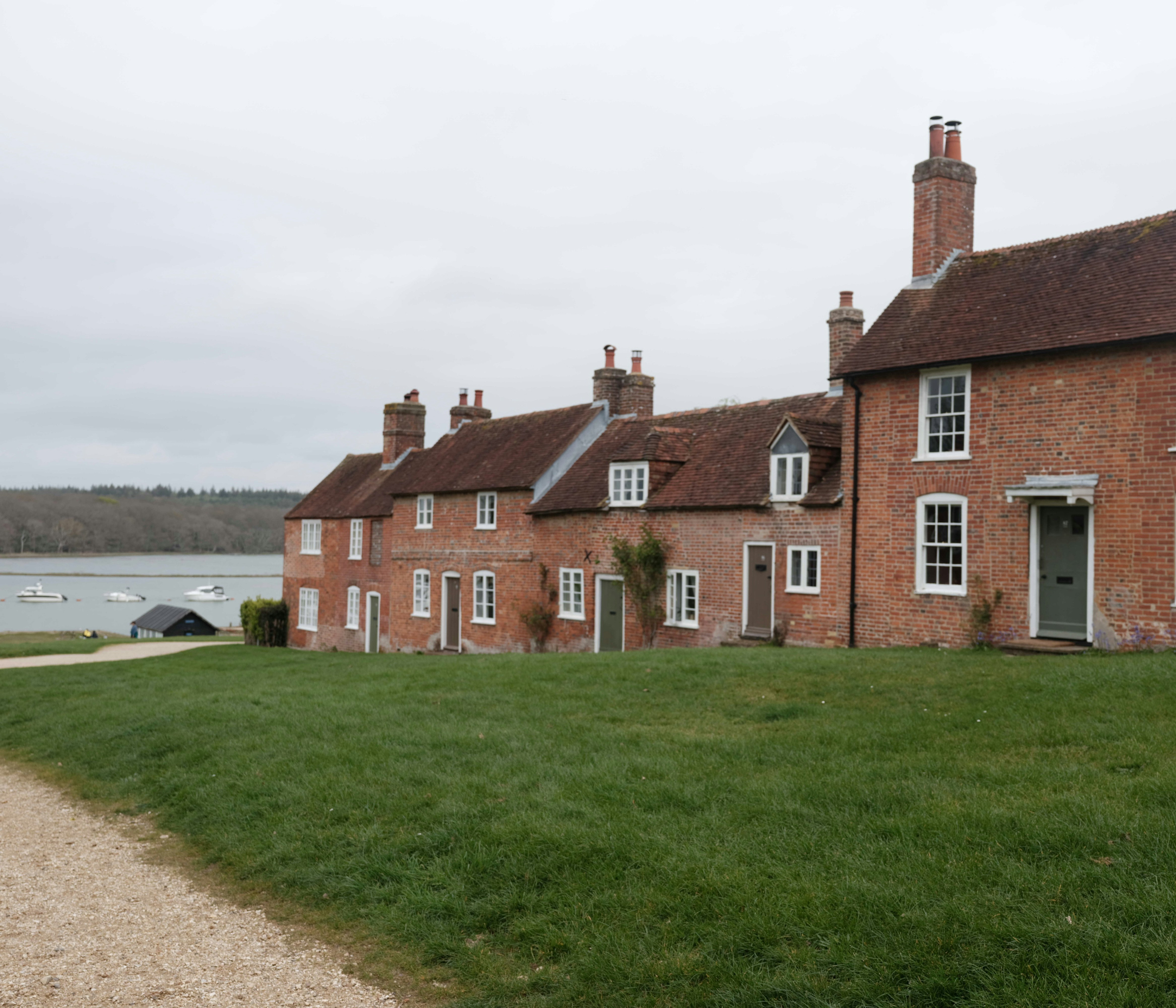 Row of brick cottages by a calm shoreline