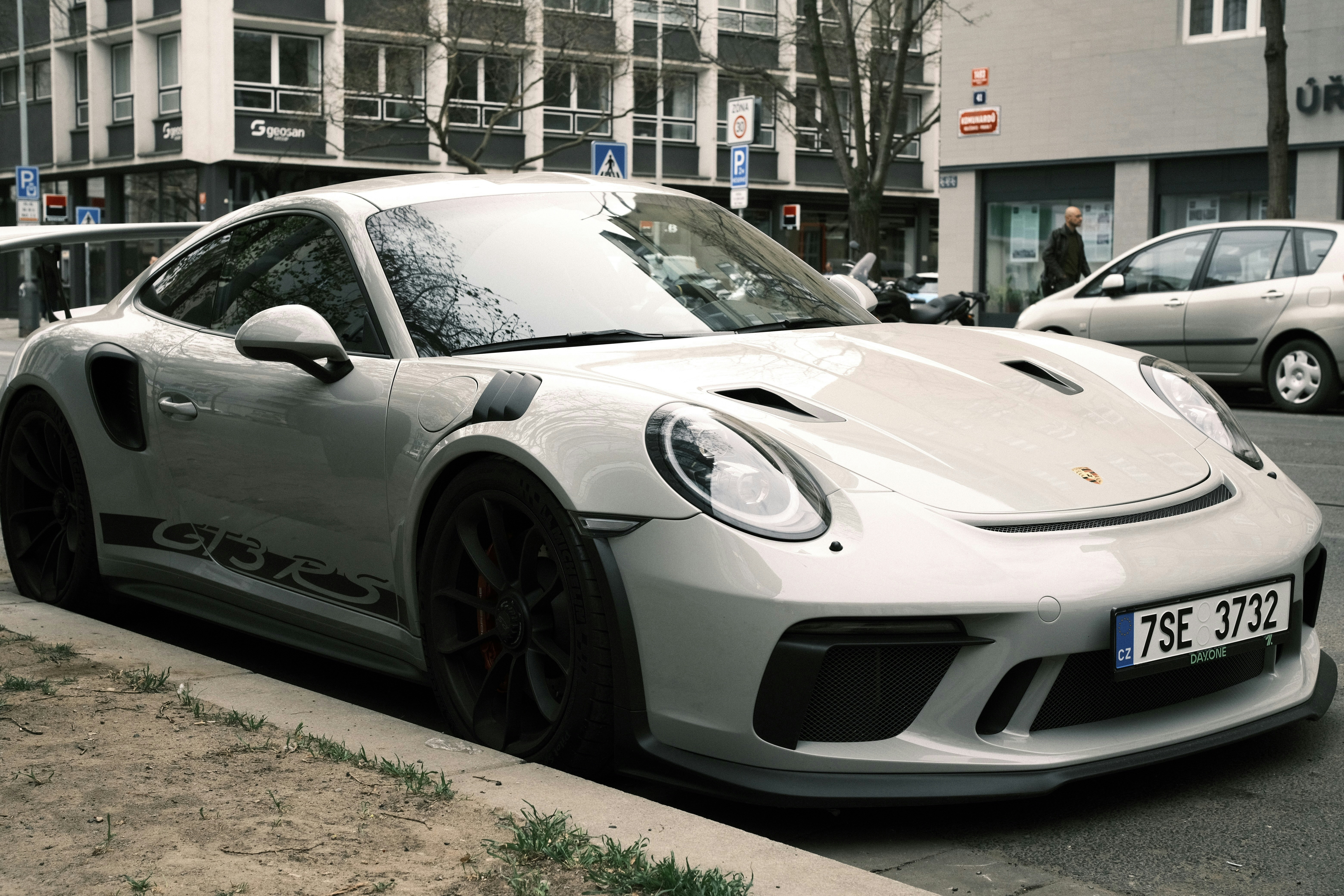 Silver Porsche 911 GT3 parked along an urban curb