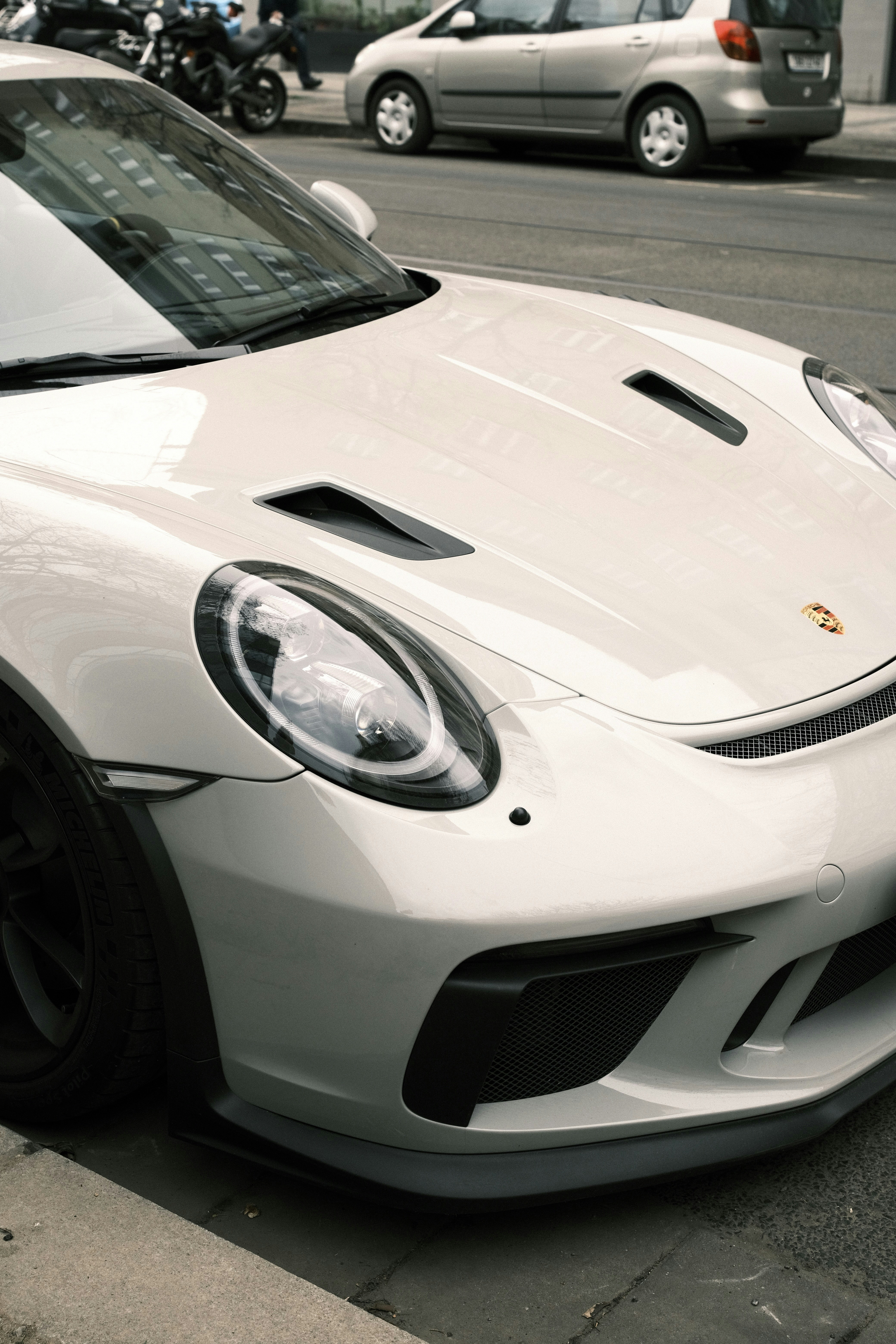 Curves of Speed: White Porsche’s Front End on a City Street