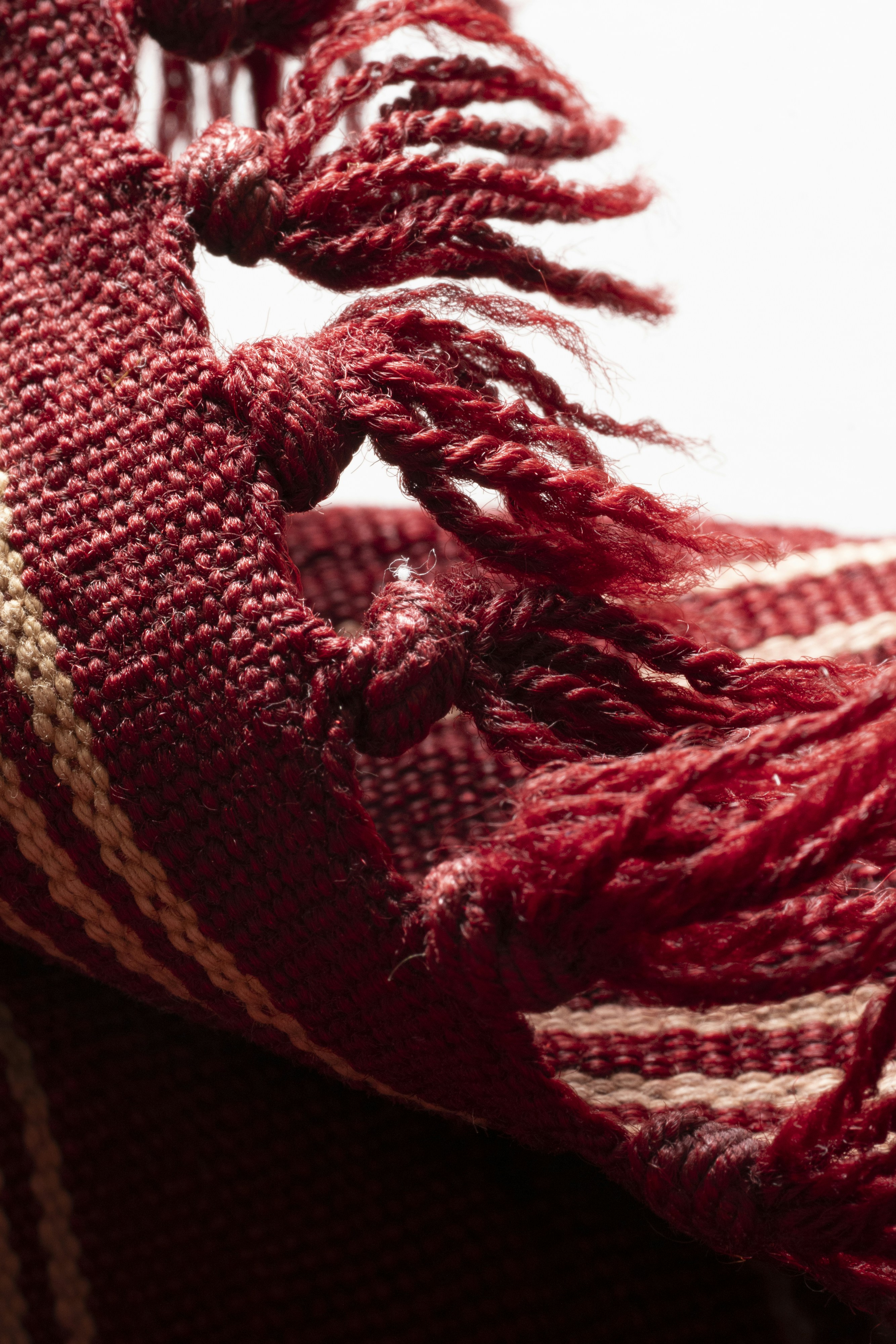 Fibers of a Redwoven Tease: Frayed Fringe Under Soft Light