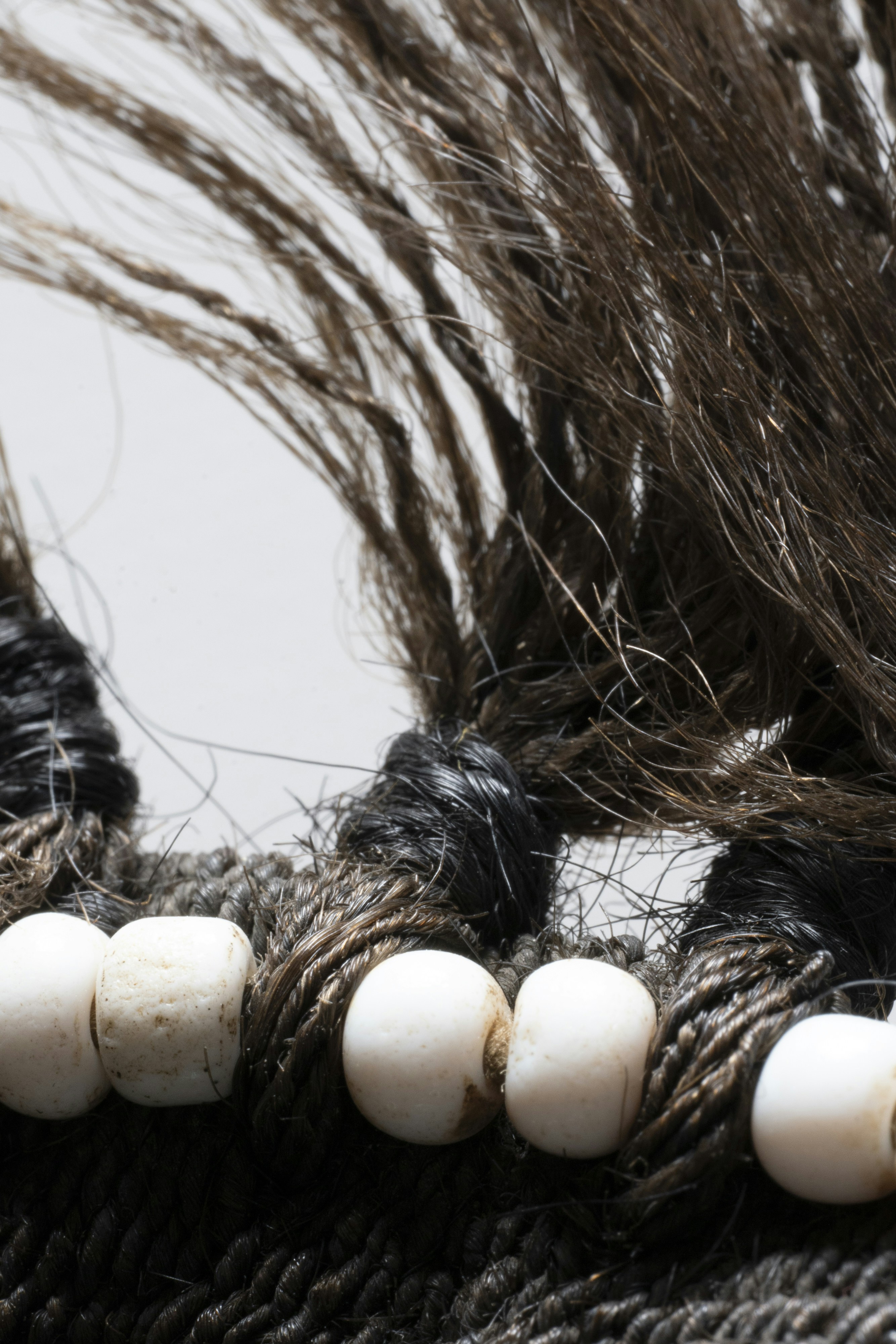 Braided strands and wooden beads: a close-up of rustic hair accessories
