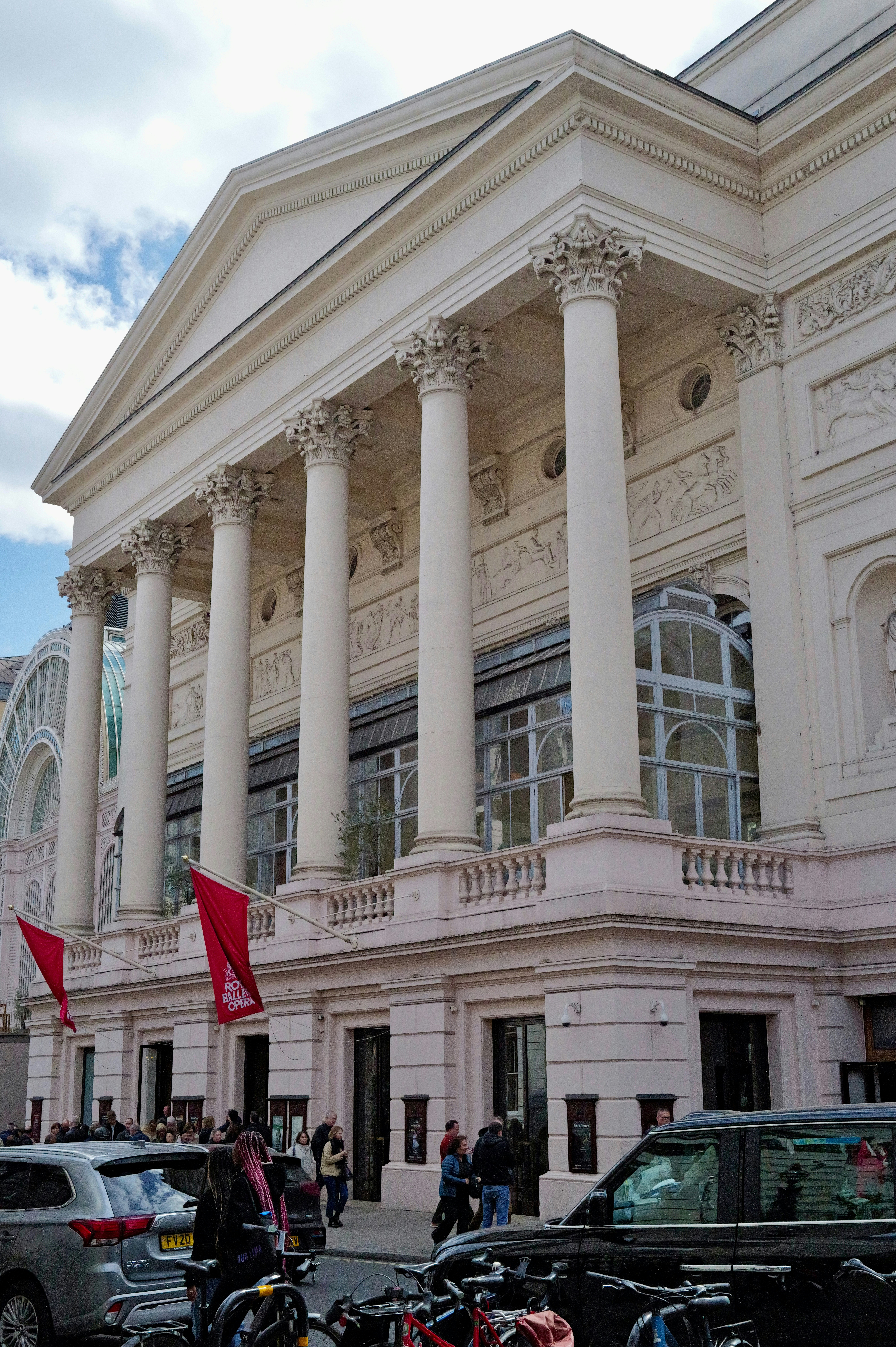Neoclassical Facade Awakens: Columns, Pediment, and a Street in Motion