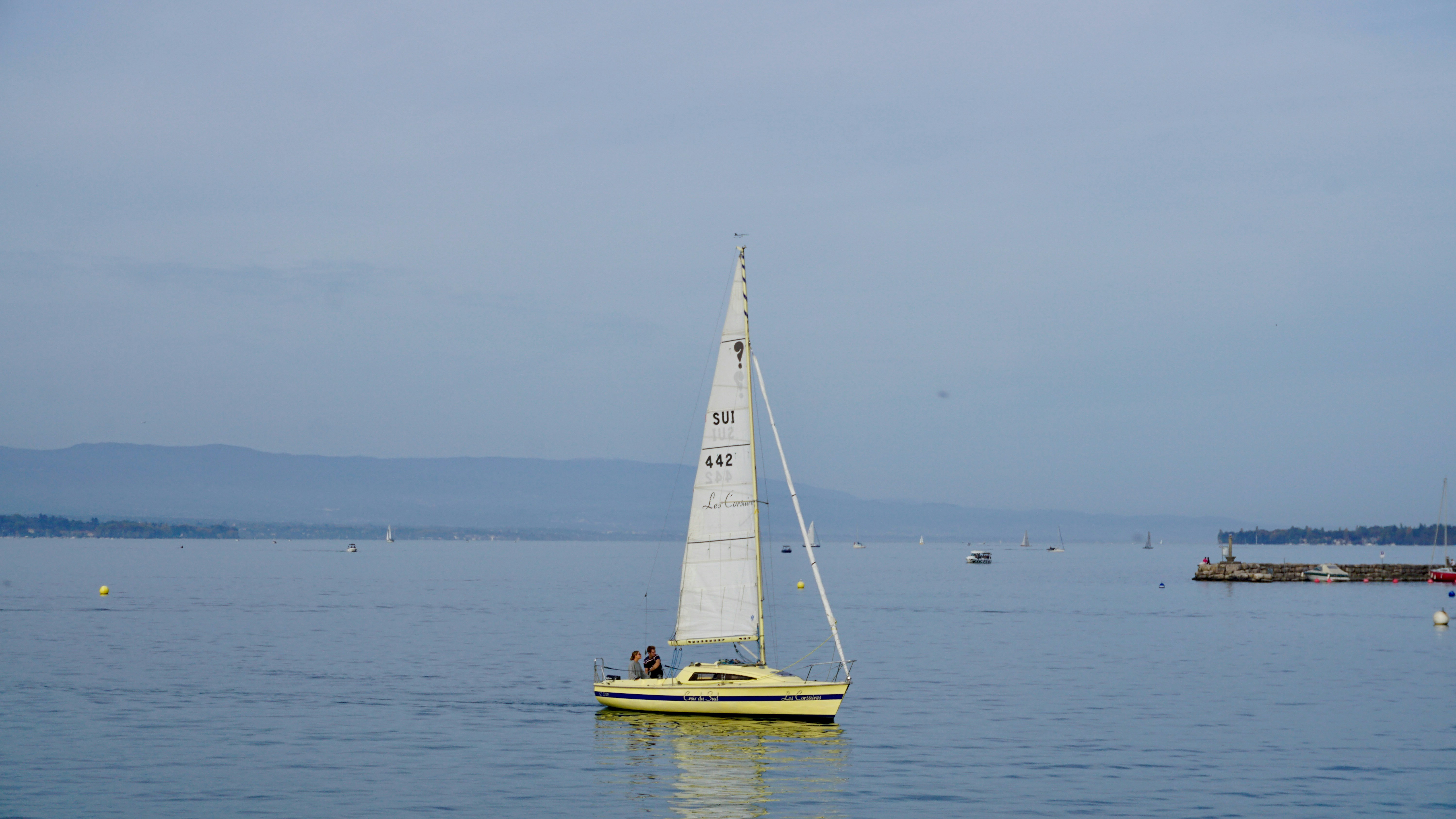 Yellow Sloop Drifting Across a Quiet Blue Horizon