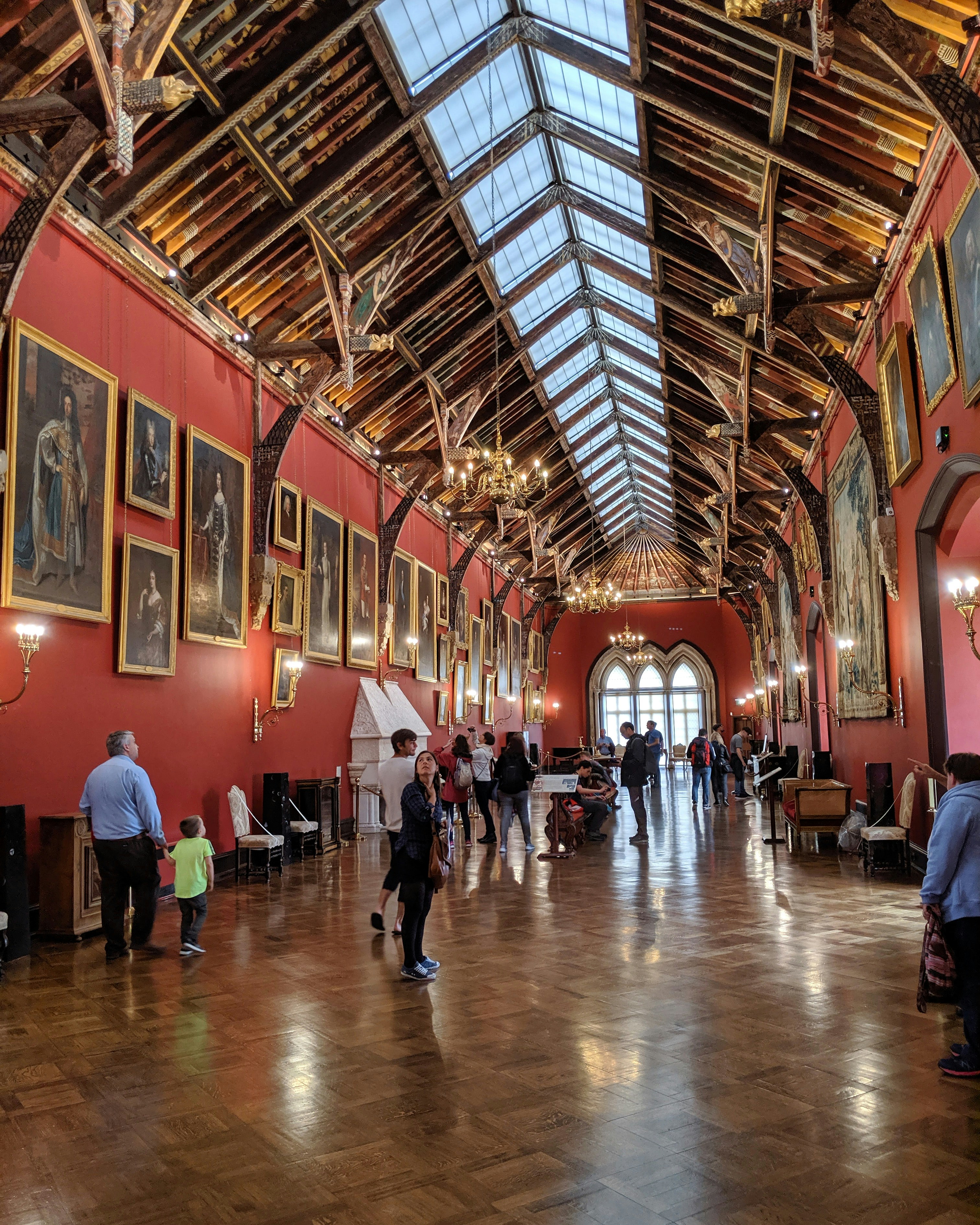Red-Walled Gallery Hall with Portraits and Glass Roof