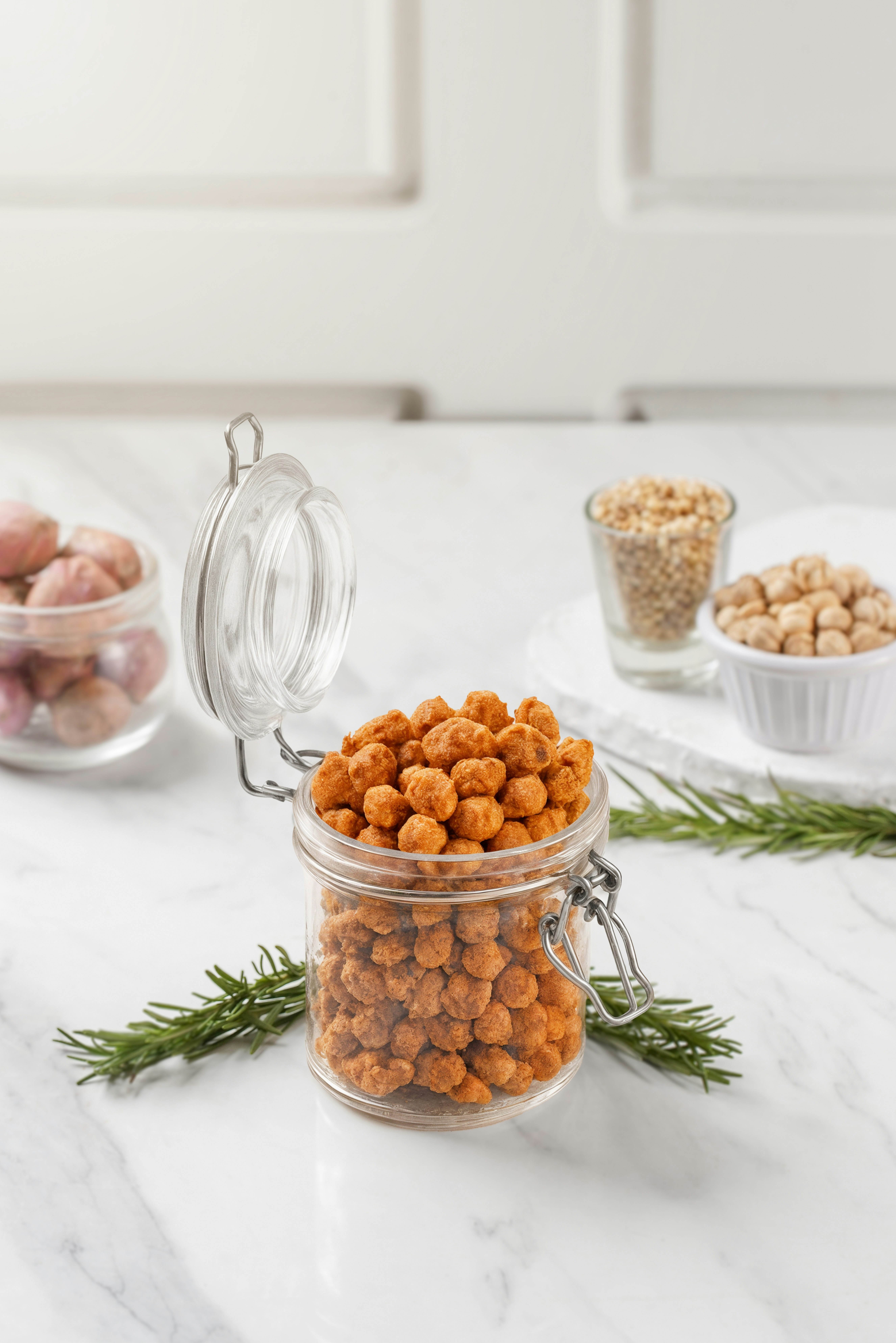 Jar of Crunchy Snack Nuts with Rosemary Garnish on Marble Surface