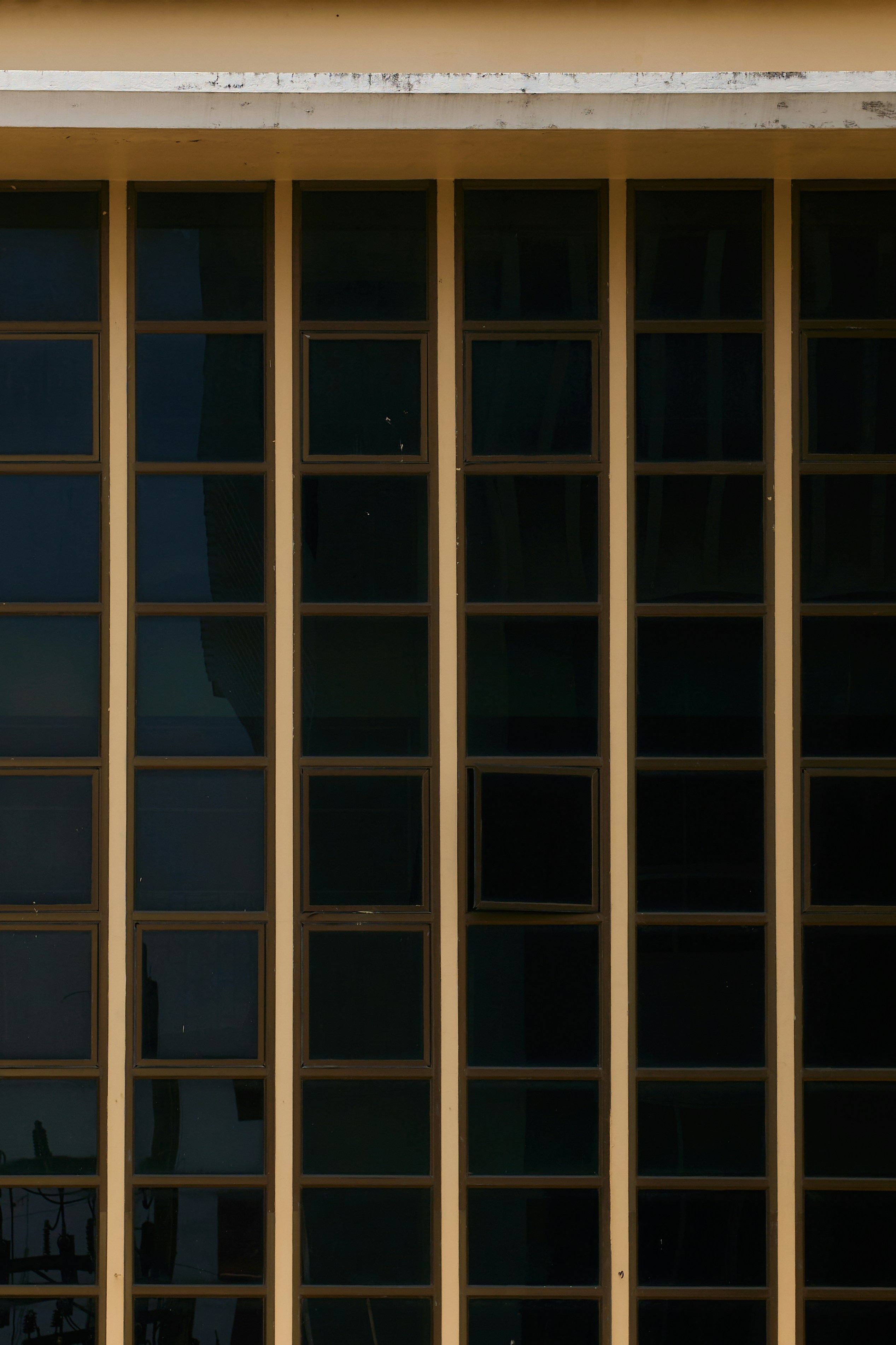 Symmetrical Grid: Golden-Framed Windows in Quiet Facade
