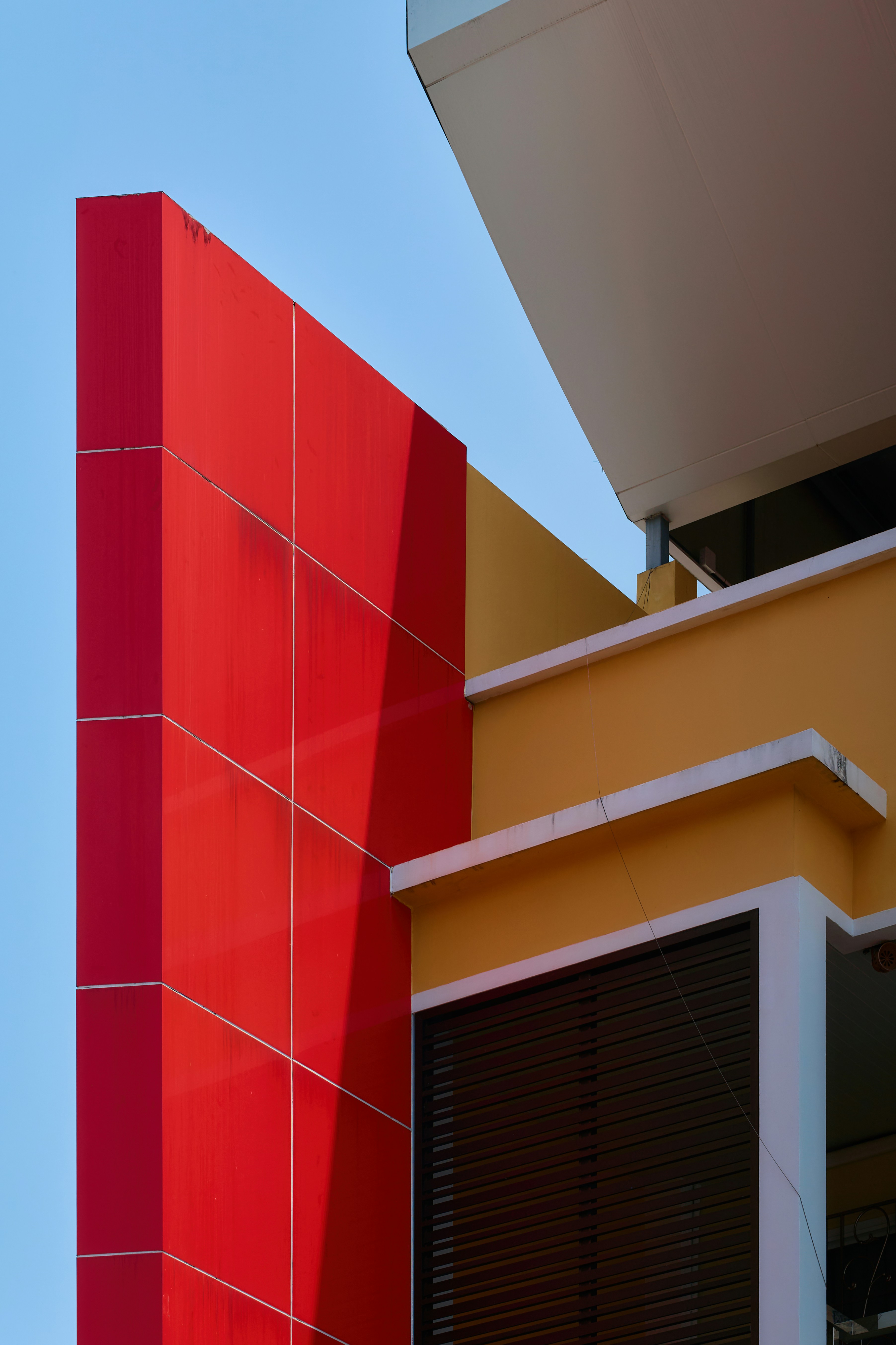 Red Towers and Sunlit Facade: A Modern Geometric Composition