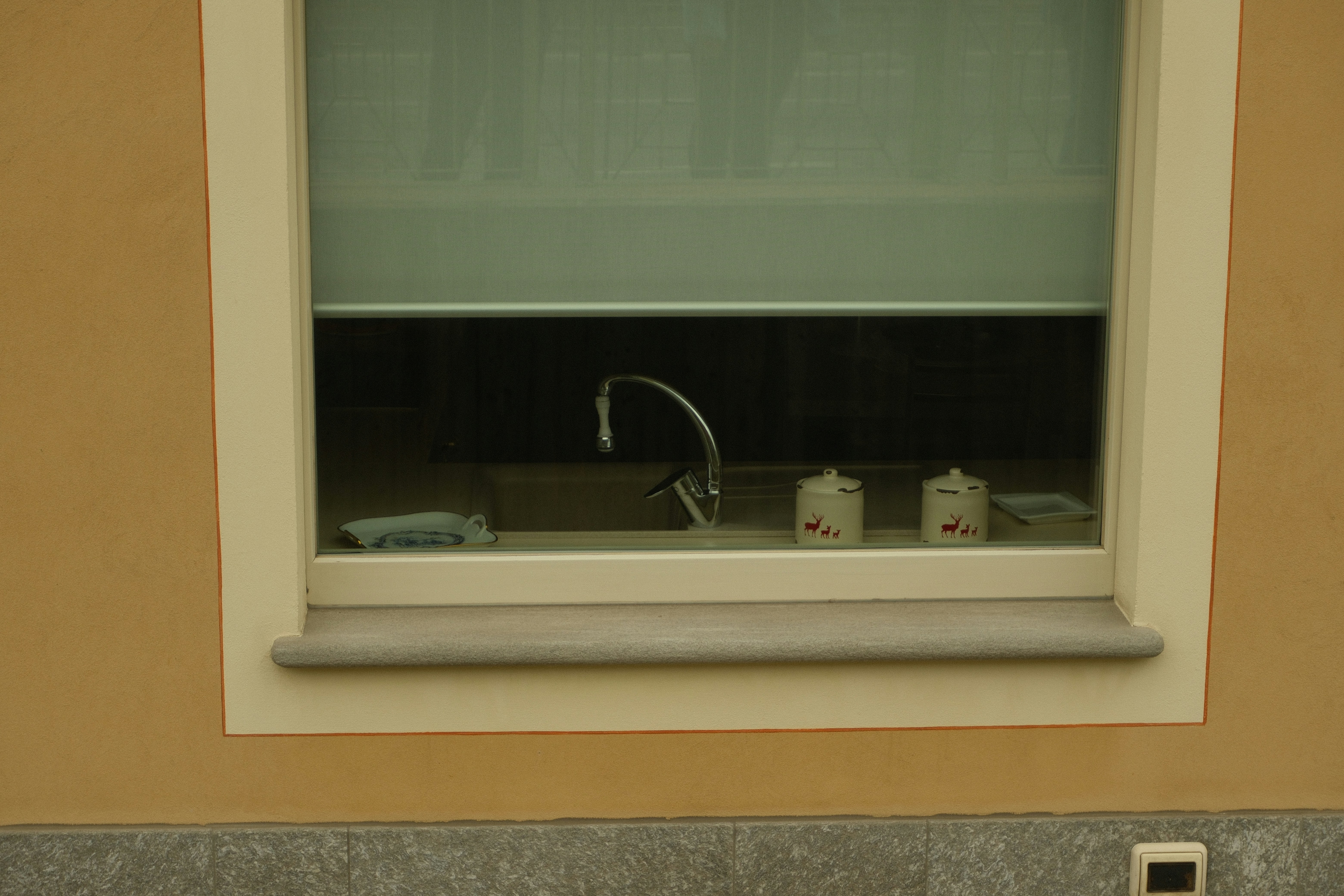 Narrow Kitchen Window Scene: Faucet and Canisters in Soft Evening Light