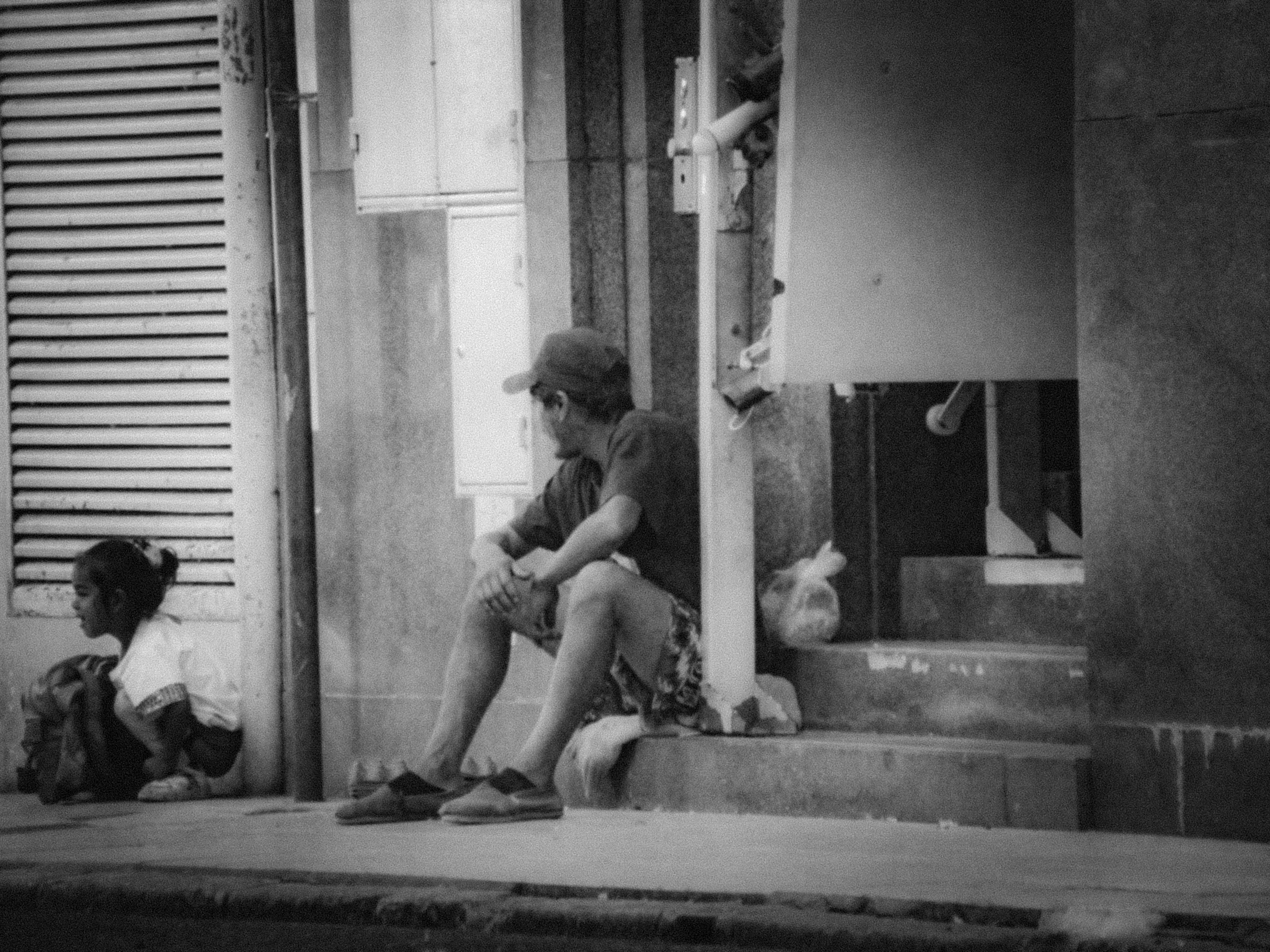 Waiting in the Shade: A Quiet Moment on the Sidewalk