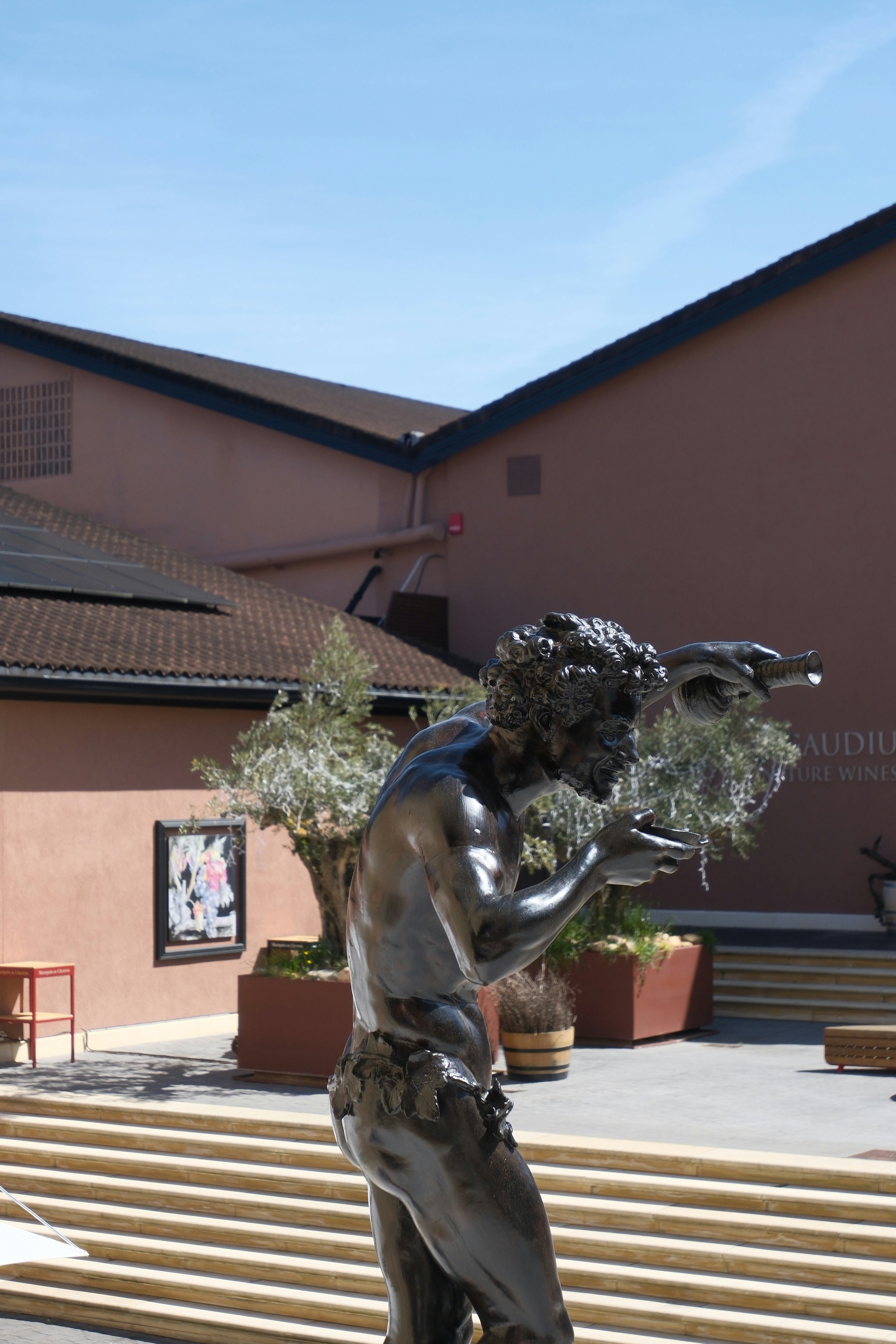 Bronze Statue in a Sunlit Courtyard Towards the Right