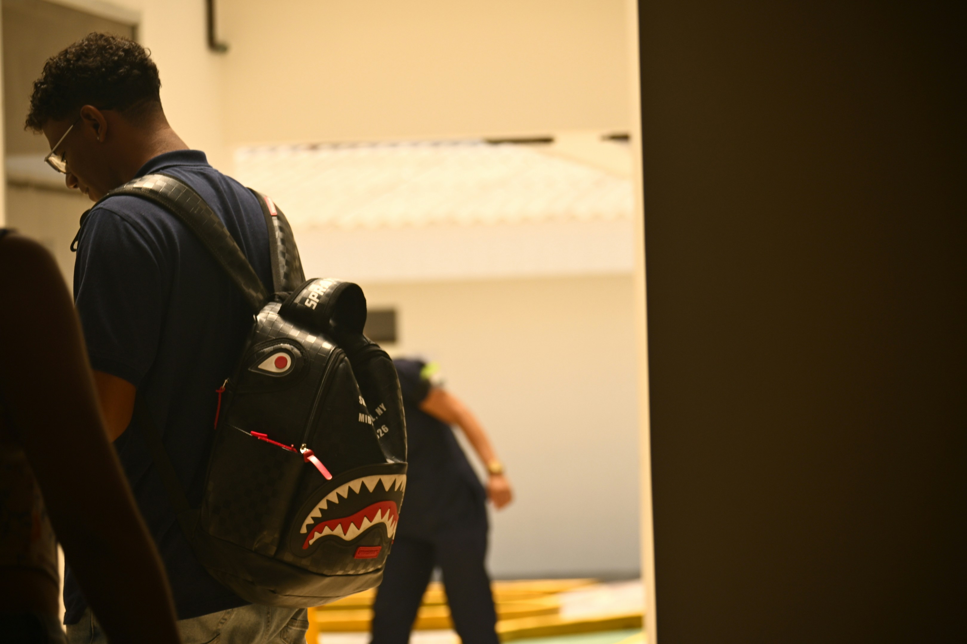Backpack with Shark Emblem in a Dim Corridor