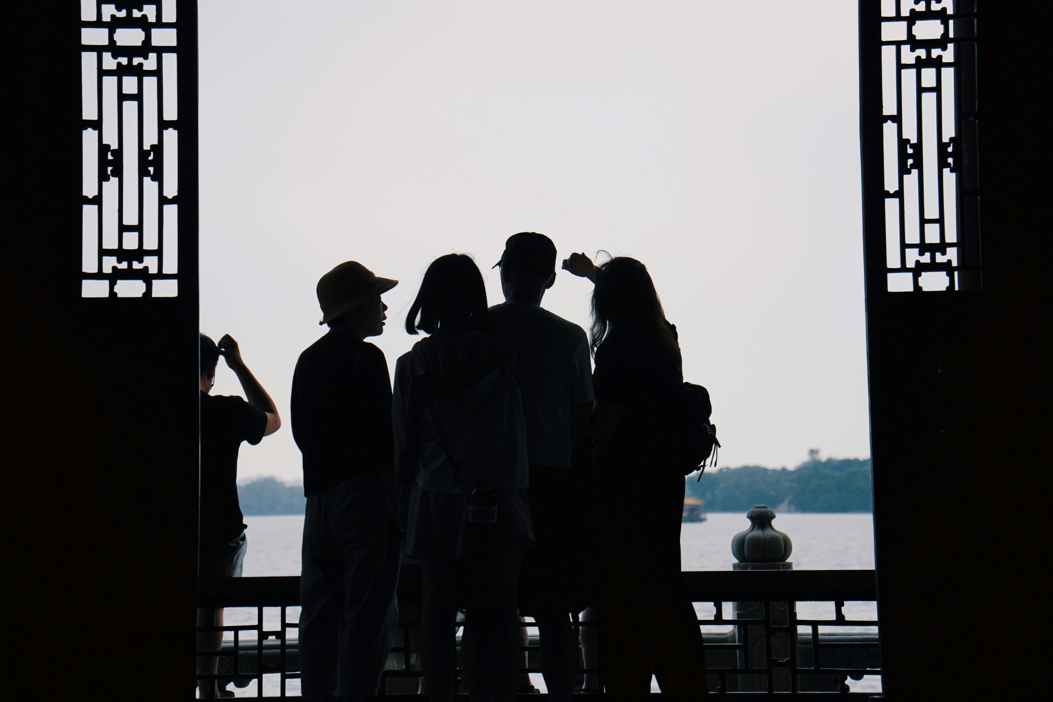 Silhouetted Friends at a Lanterned Terrace Overlooking Water