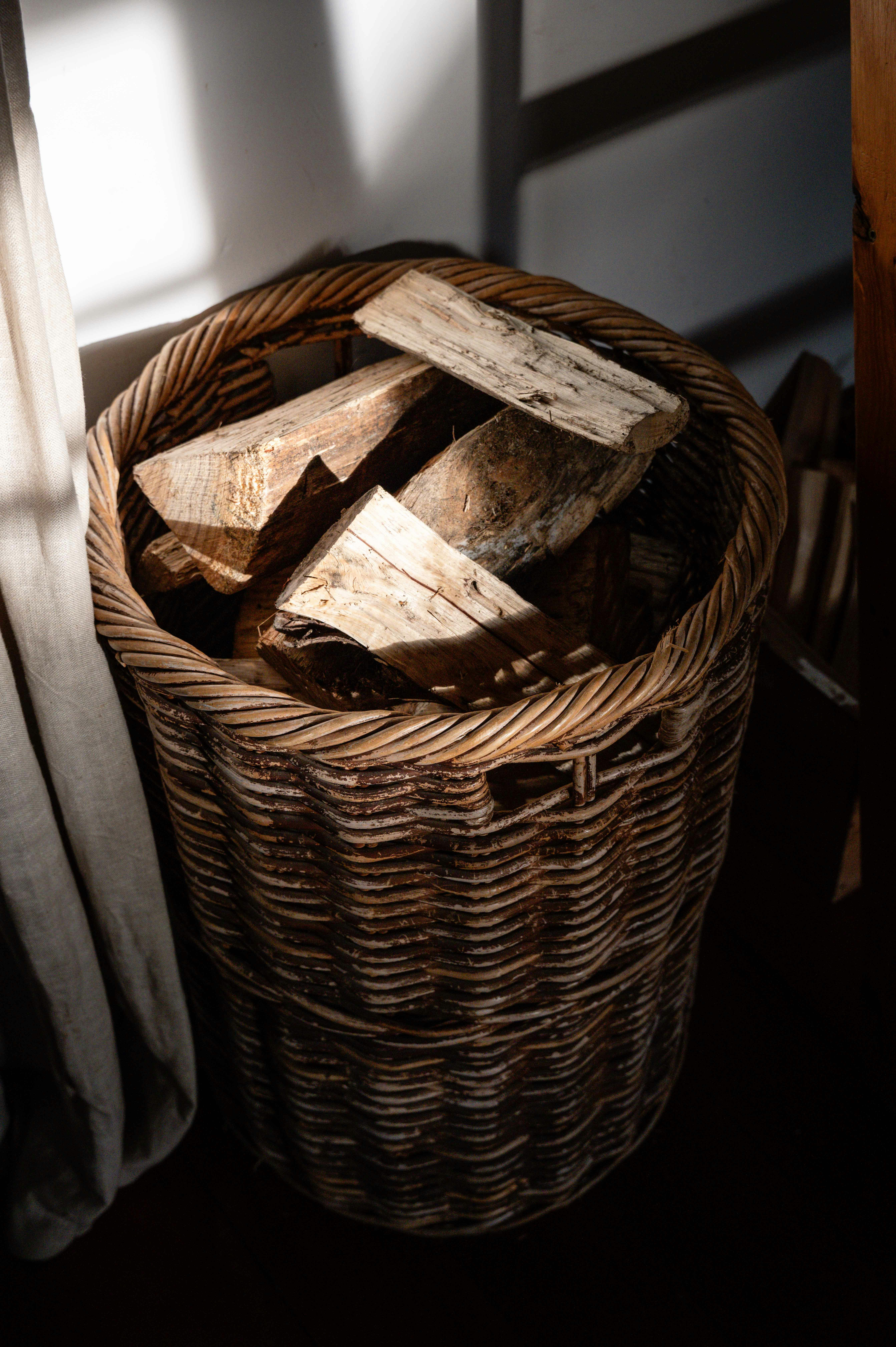 Sunlit Logs in a Woven Basket: Quiet Hearthside