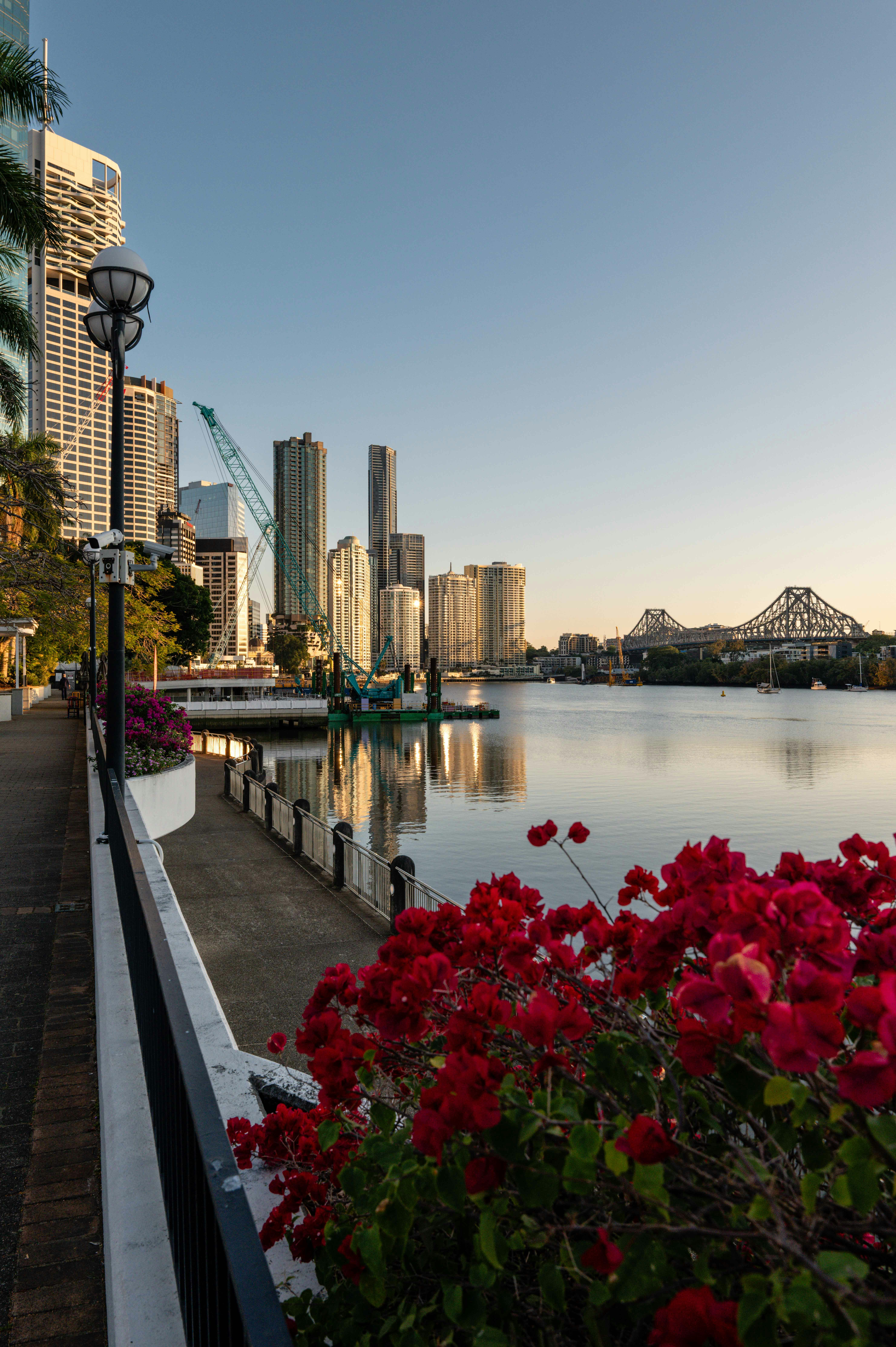 Sunlit Waterfront Promenade with Urban Cityscape