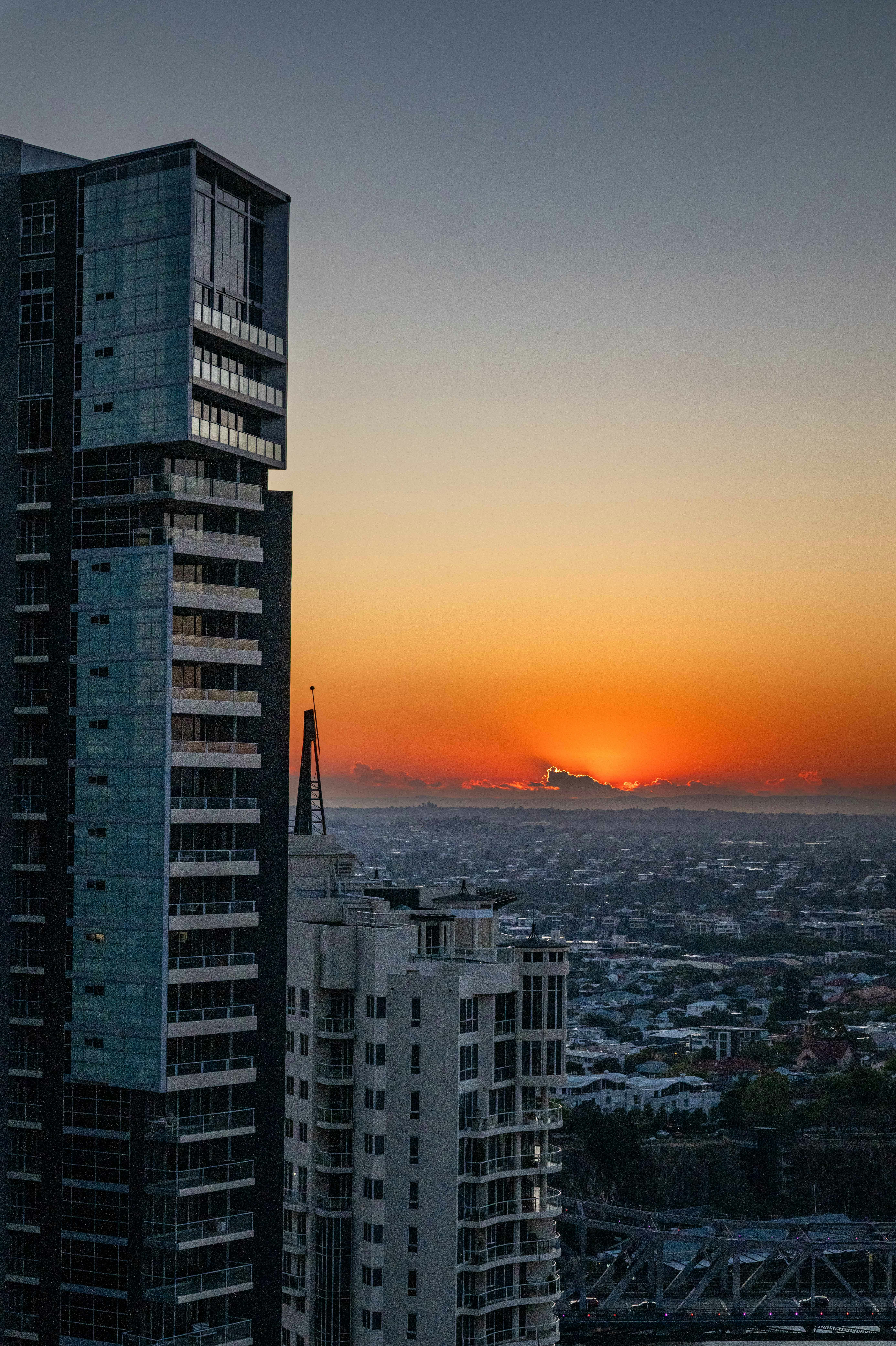Sunset over the urban horizon framed by glass towers
