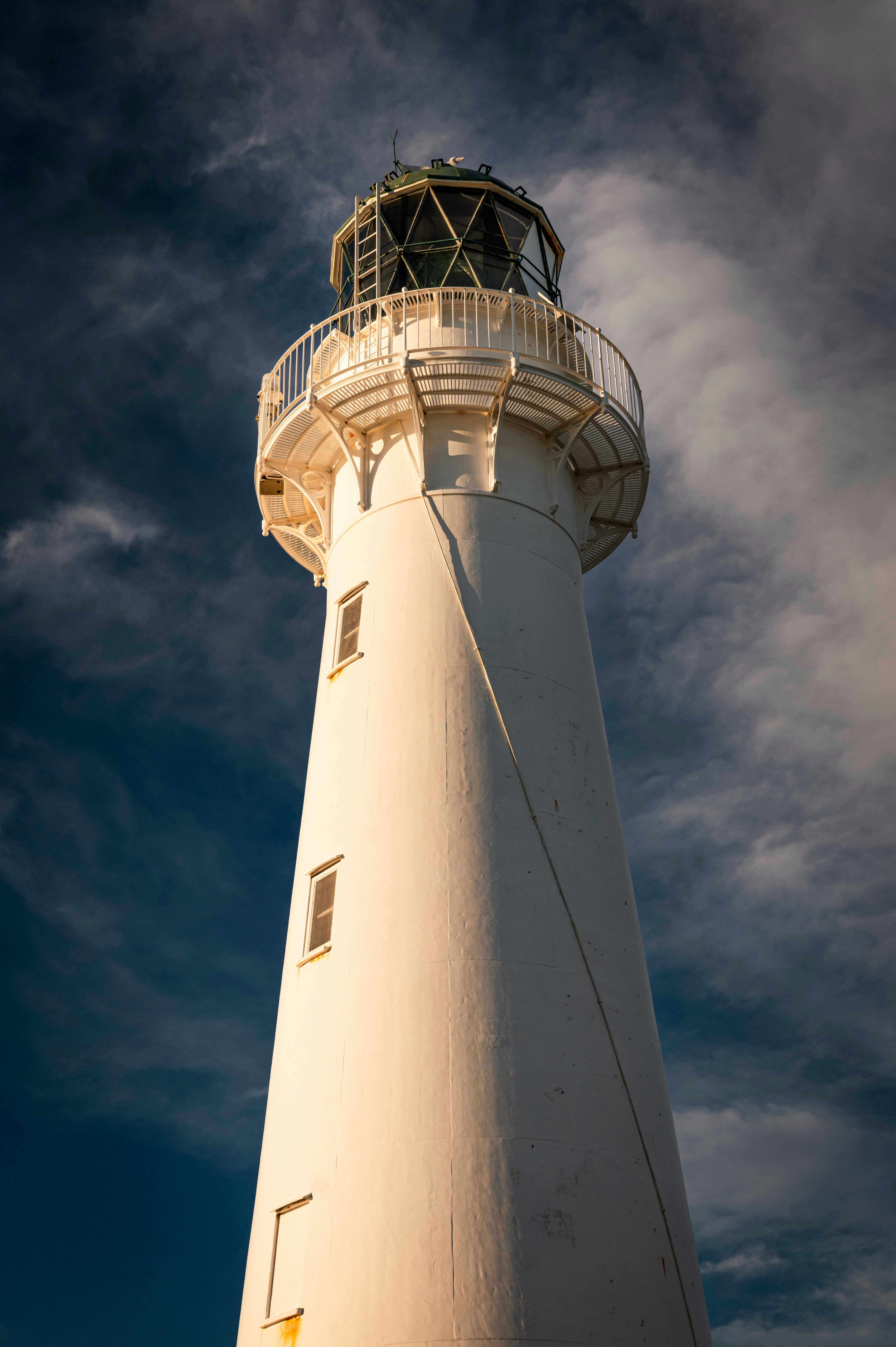 Beacon of Light: The Lighthouse Tower Reaching Toward a Sky of Tempest and Calm