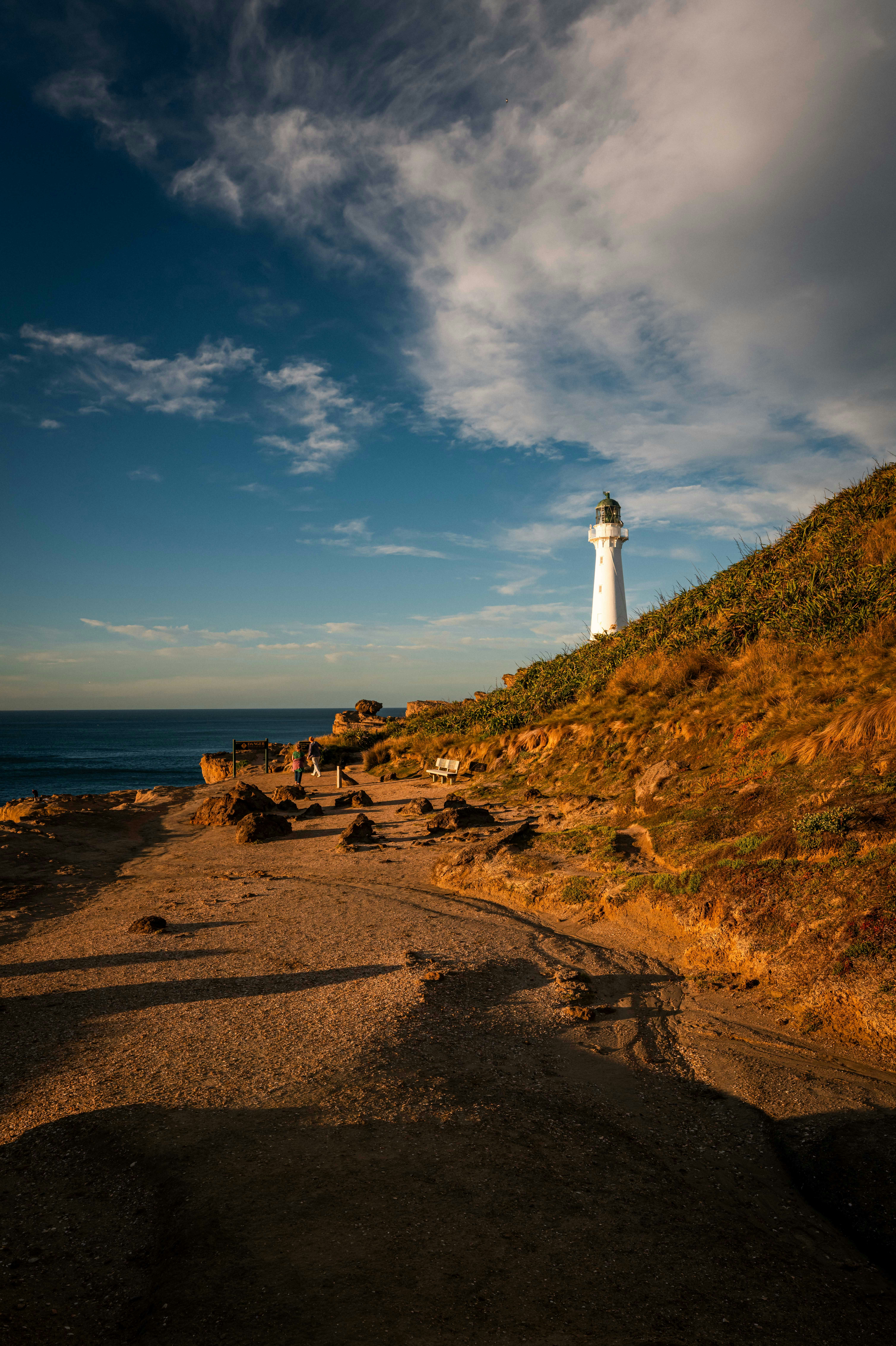 Lighthouse at Dusk: Coastline Bathed in Golden Light