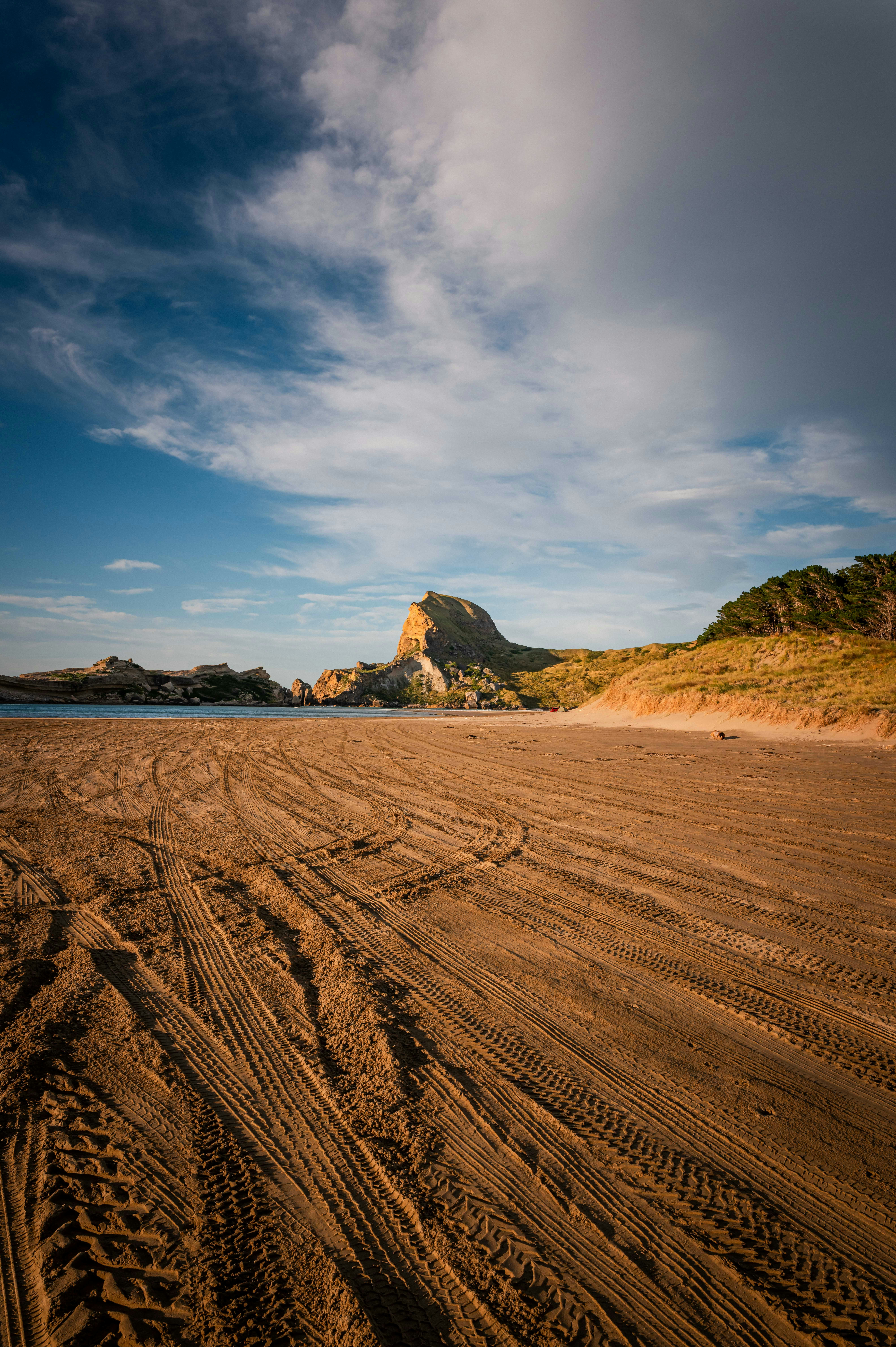 Sculpted Sand and Coastal Promontory under a Wide Sky