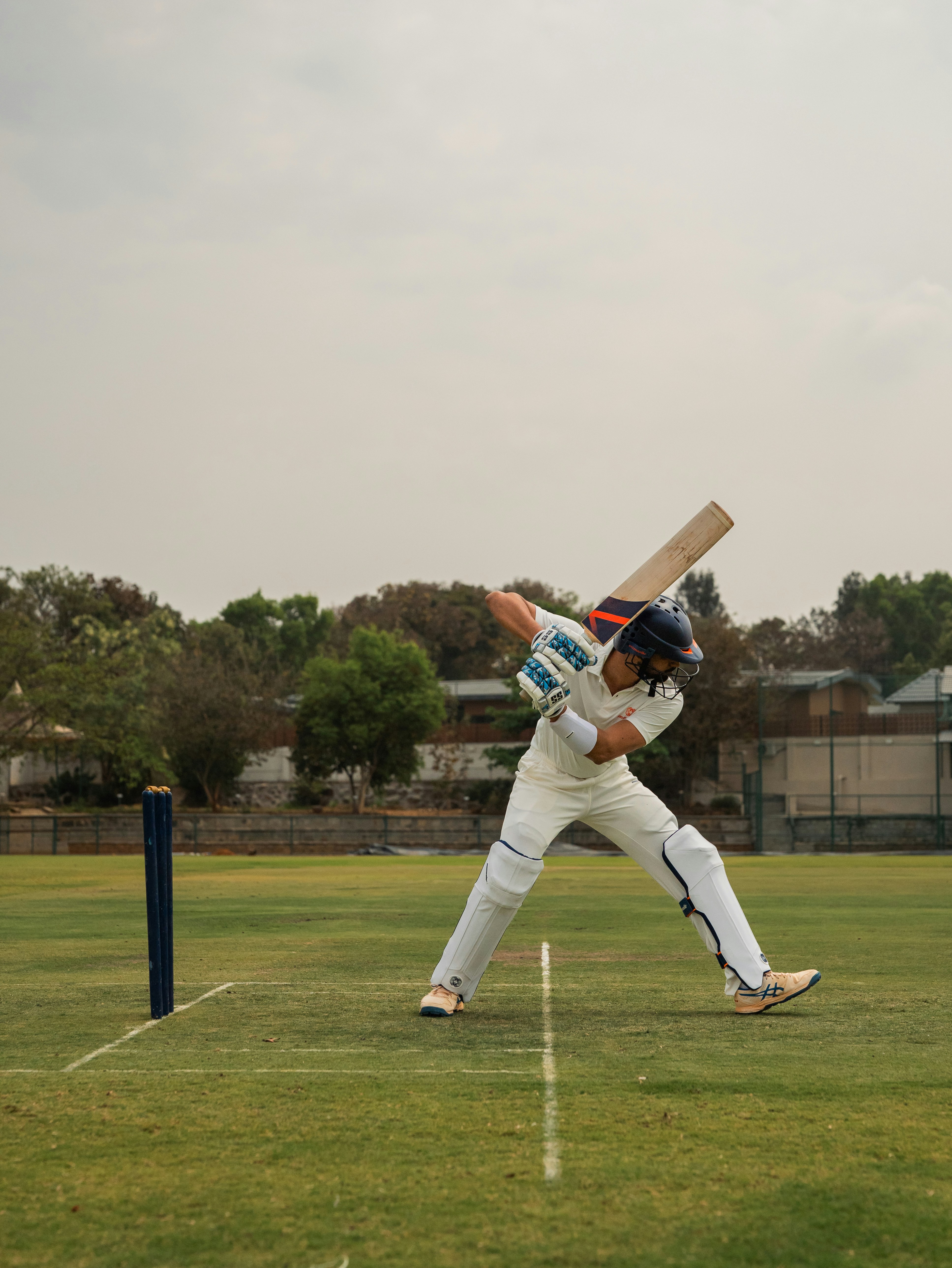Cricket Bat in Mid-Swing: A Batter’s Moment on the Green Field